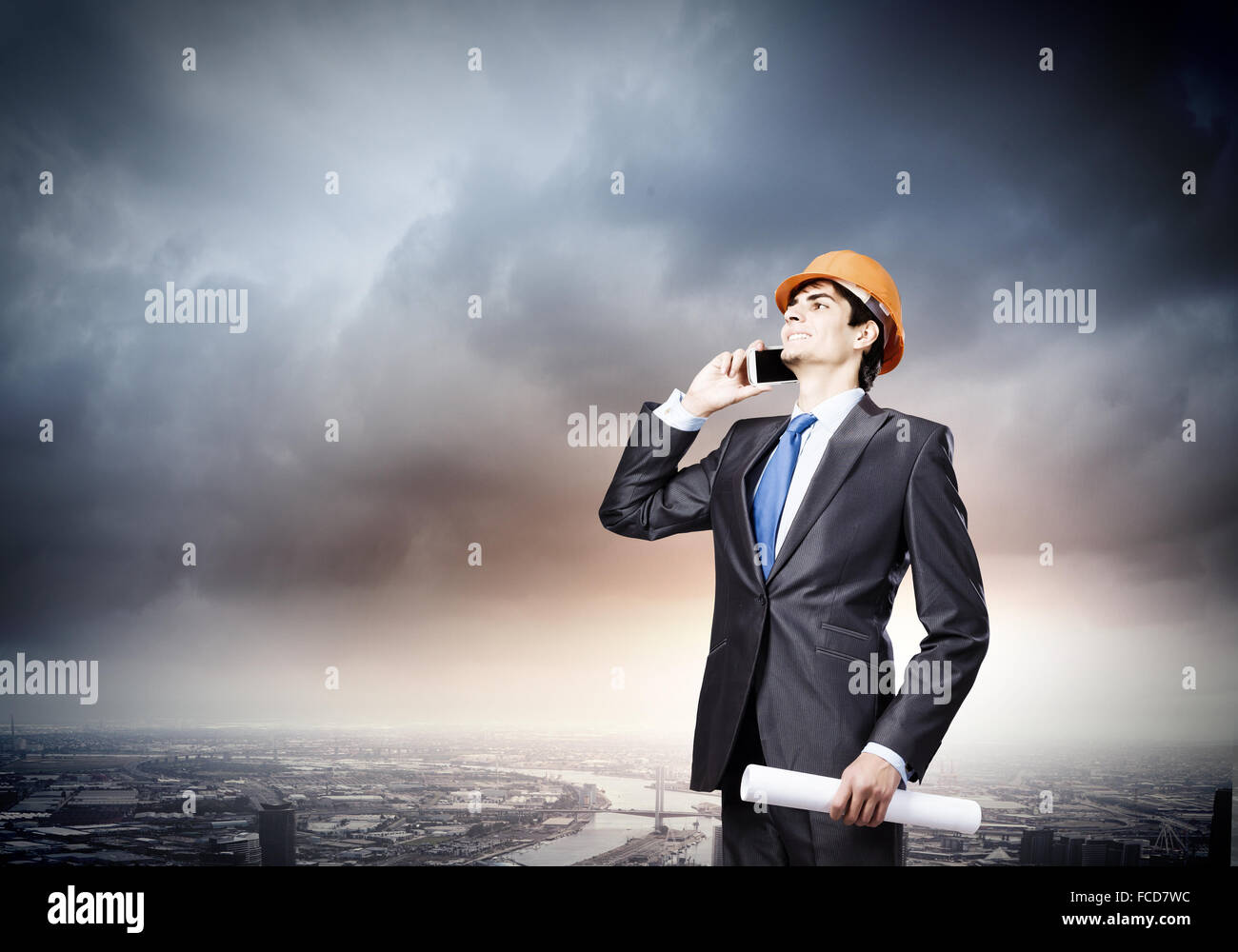 Young man engineer in helmet talking on mobile phone Stock Photo - Alamy