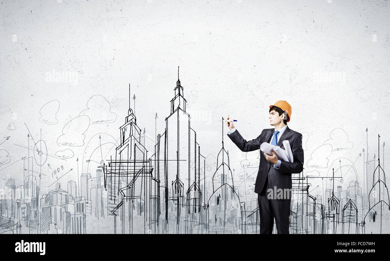 Young man engineer in helmet drawing construction project Stock Photo ...