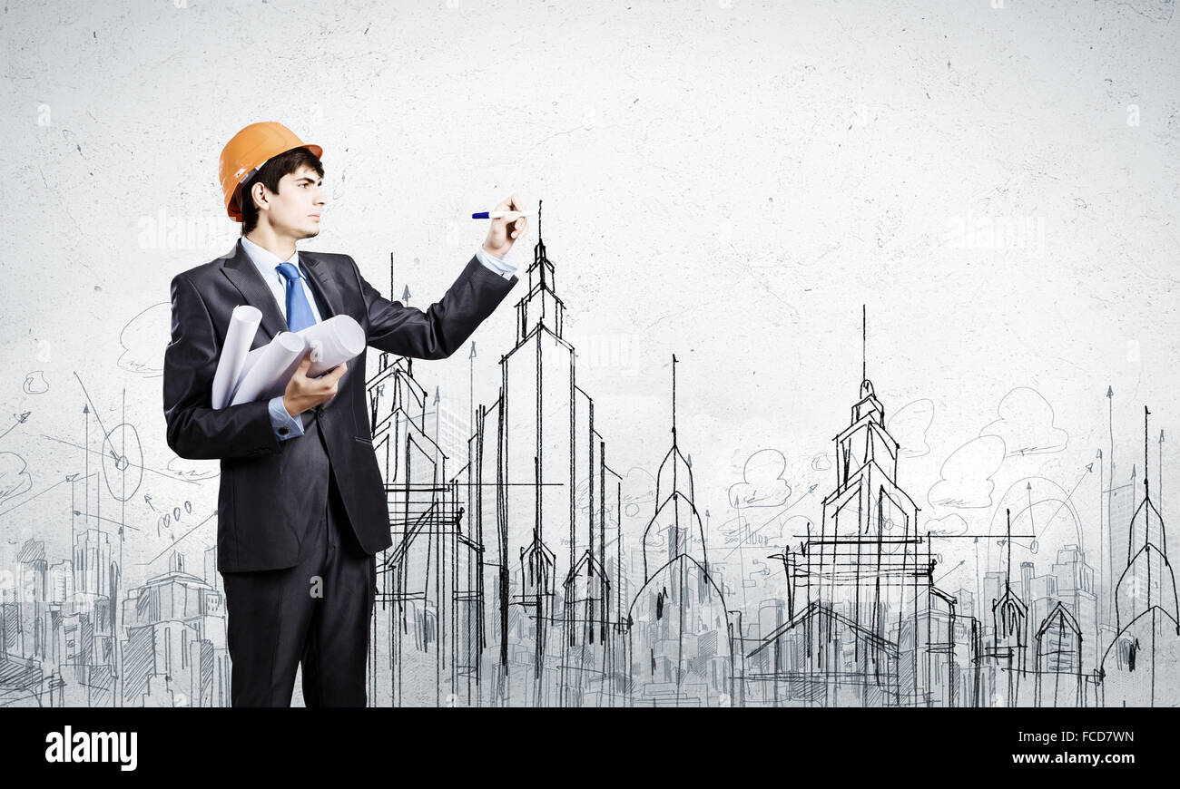 Young man engineer in helmet drawing construction project Stock Photo ...