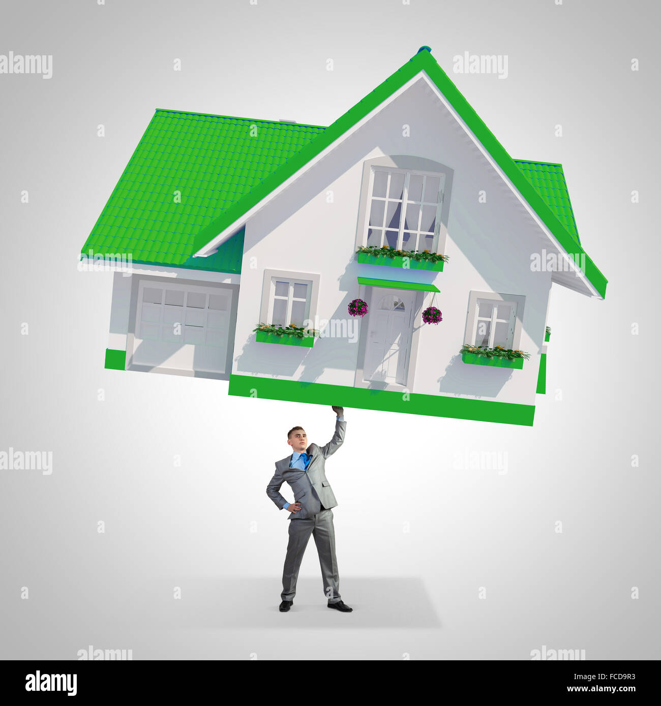 Young businessman lifting huge model of house above head Stock Photo ...