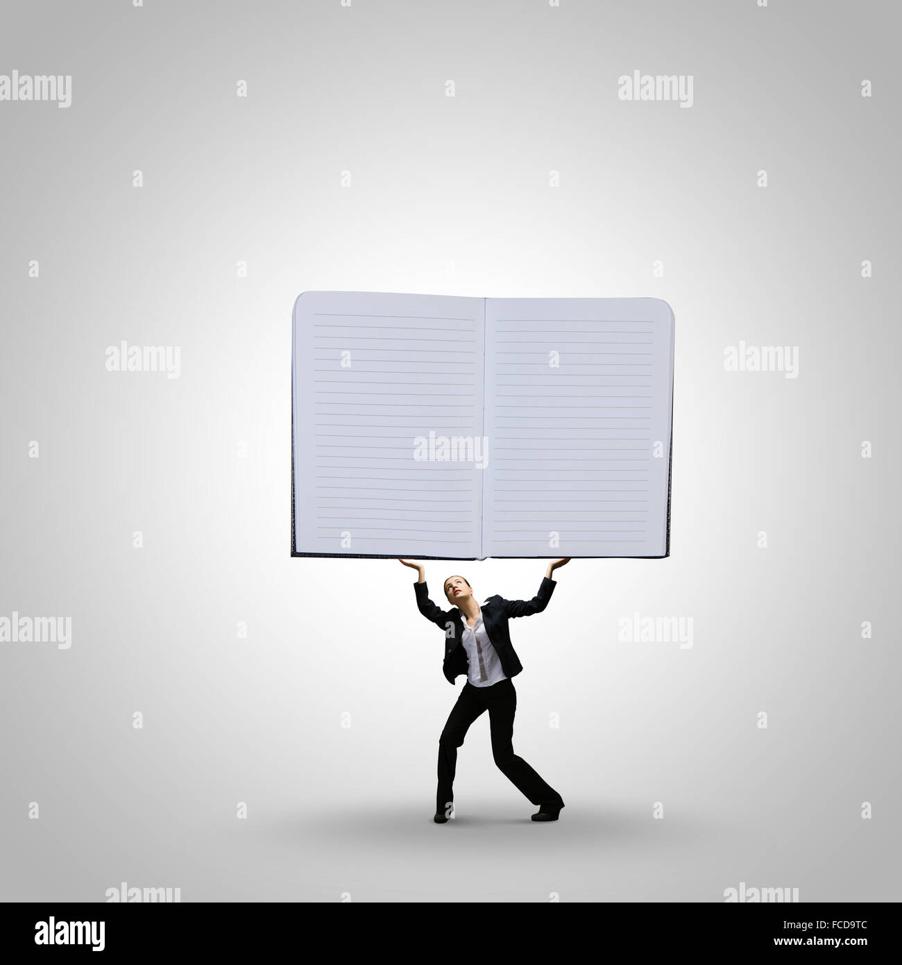 Young businesswoman lifting huge notepad above head Stock Photo - Alamy