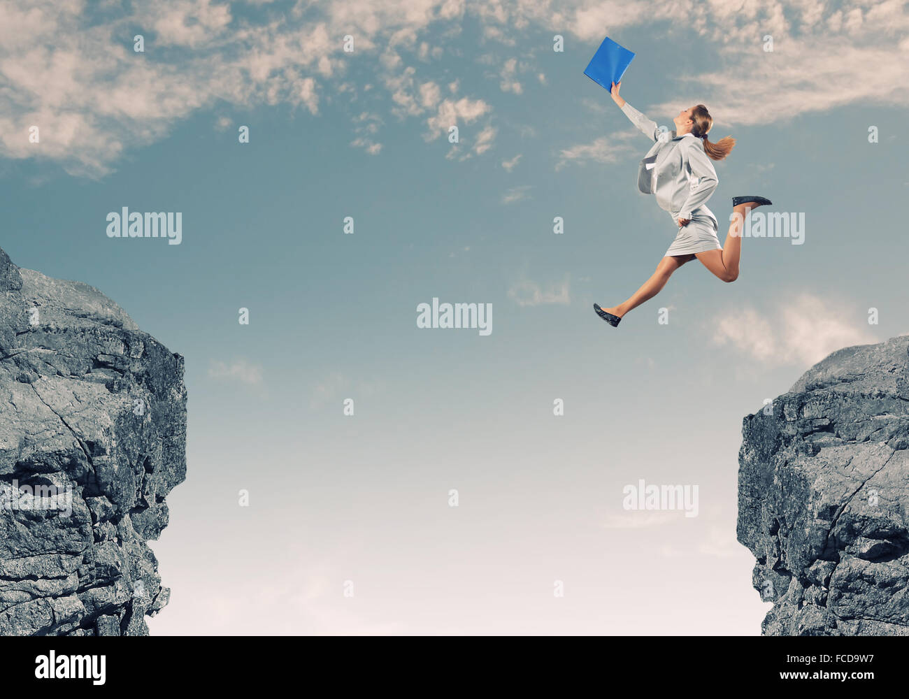 Young businesswoman jumping over gap. Risk concept Stock Photo - Alamy