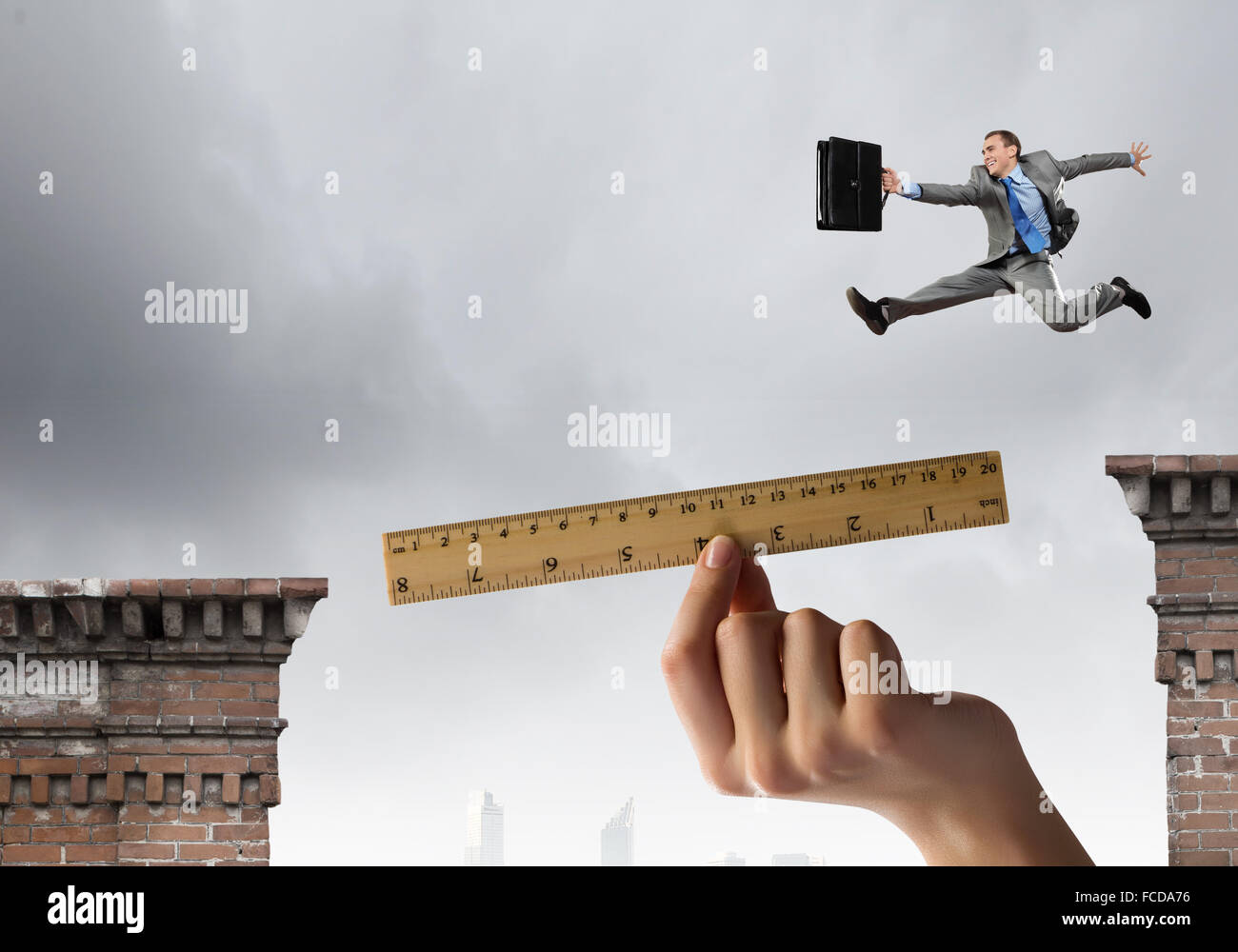Young businessman jumping over gap. Risk concept Stock Photo - Alamy