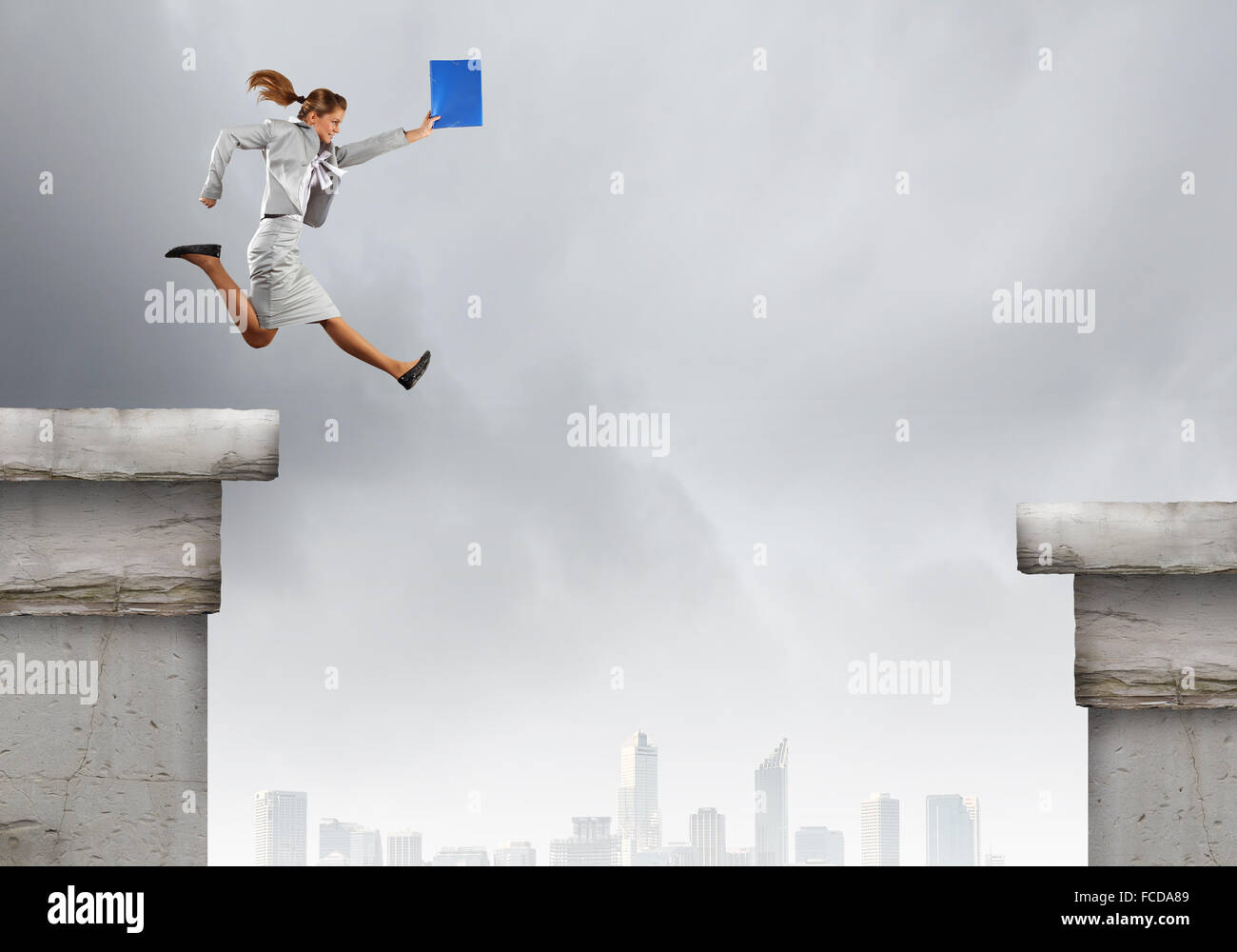 Young businesswoman jumping over gap. Risk concept Stock Photo - Alamy
