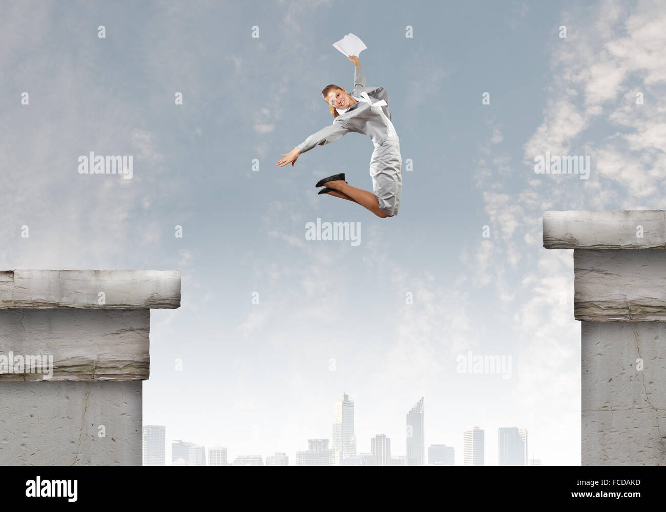 Young businesswoman jumping over gap. Risk concept Stock Photo - Alamy