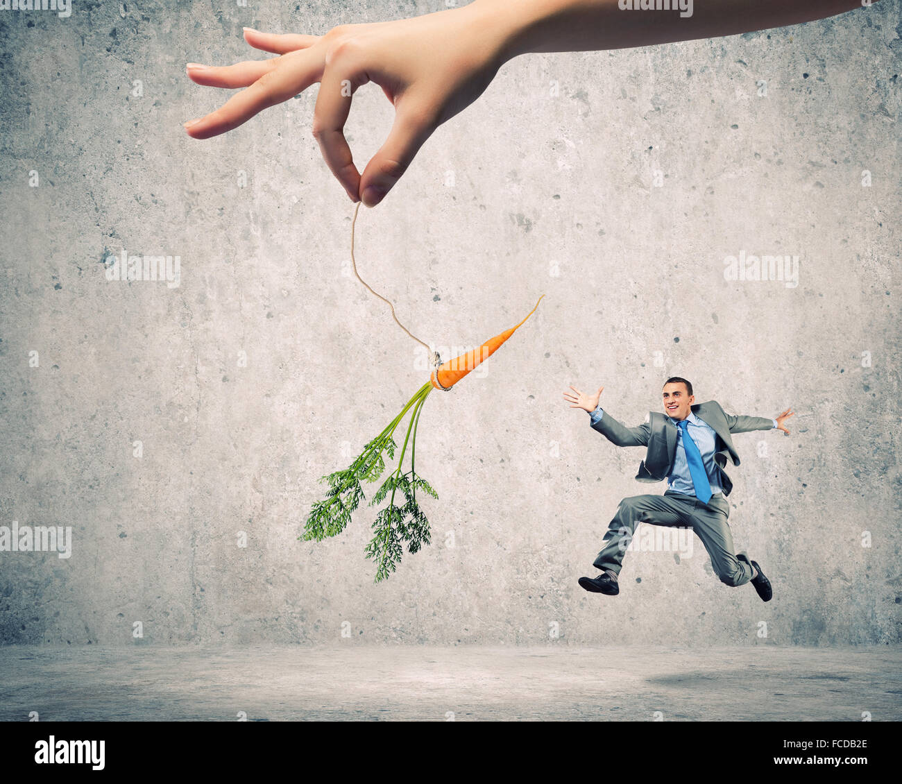 Funny image of businessman chased with carrot Stock Photo - Alamy