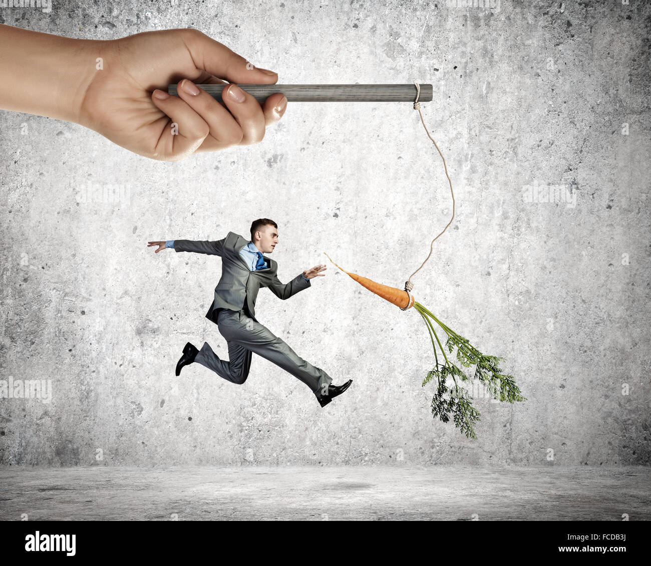 Funny image of businessman chased with carrot Stock Photo - Alamy