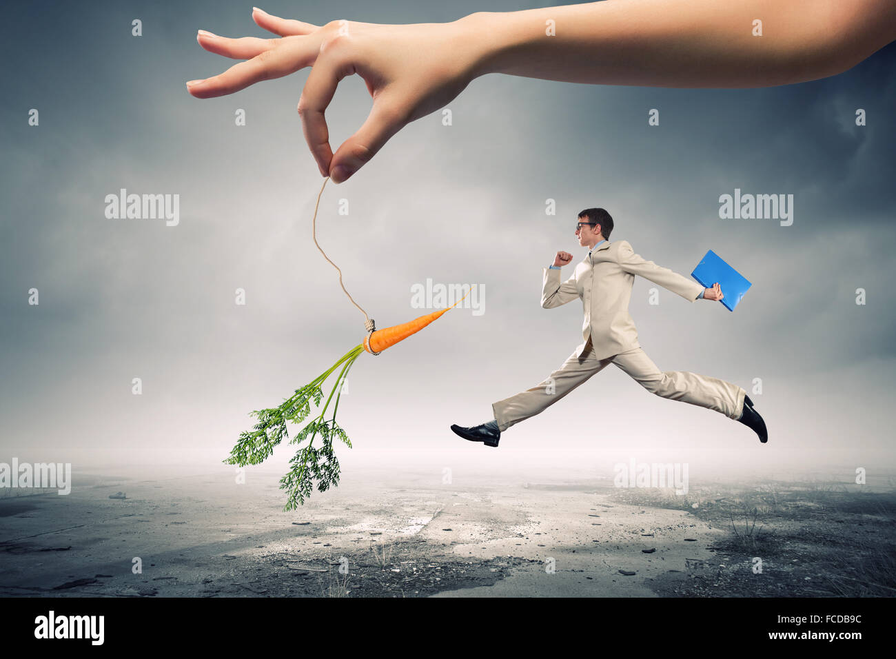 Funny image of businessman chased with carrot Stock Photo - Alamy