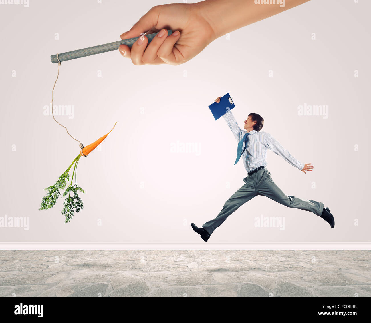 Funny image of businessman chased with carrot Stock Photo - Alamy