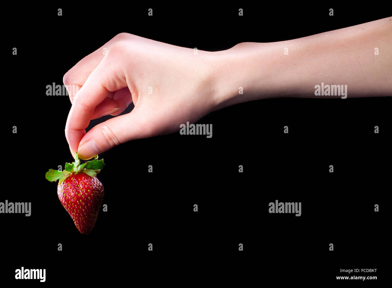 Hand holding a strawberry Stock Photo - Alamy