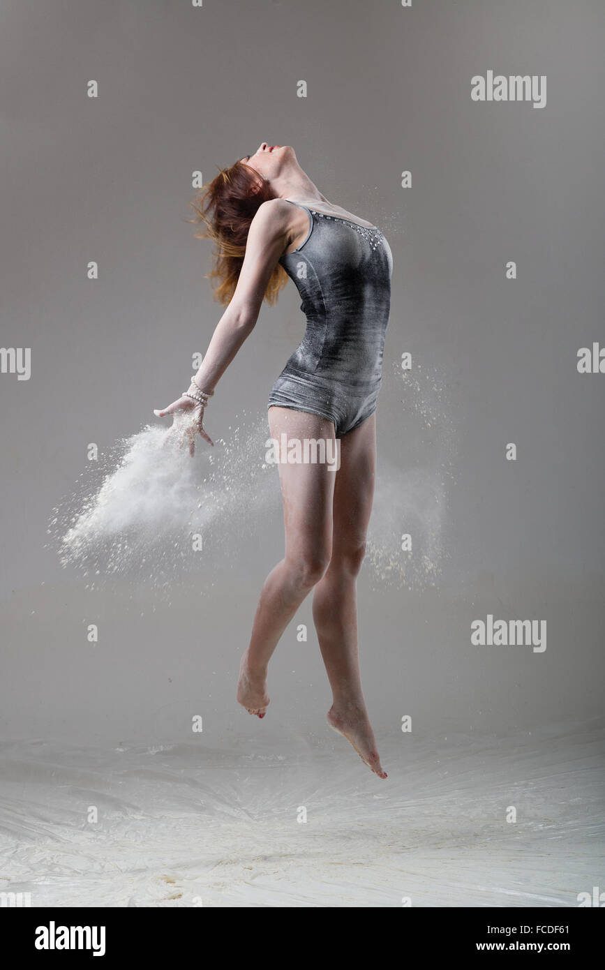 Beautiful expressive ballet dancer posing with flour at studio Stock ...