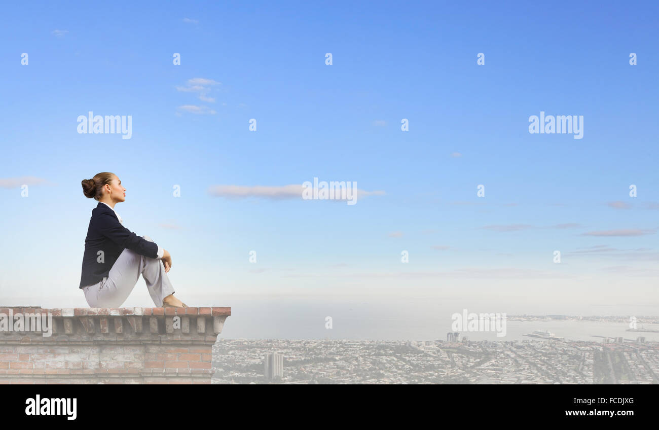 Young attractive lady sitting on top of building Stock Photo - Alamy
