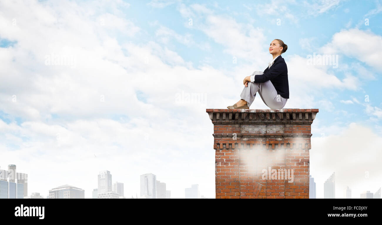 Young attractive lady sitting on top of building Stock Photo - Alamy