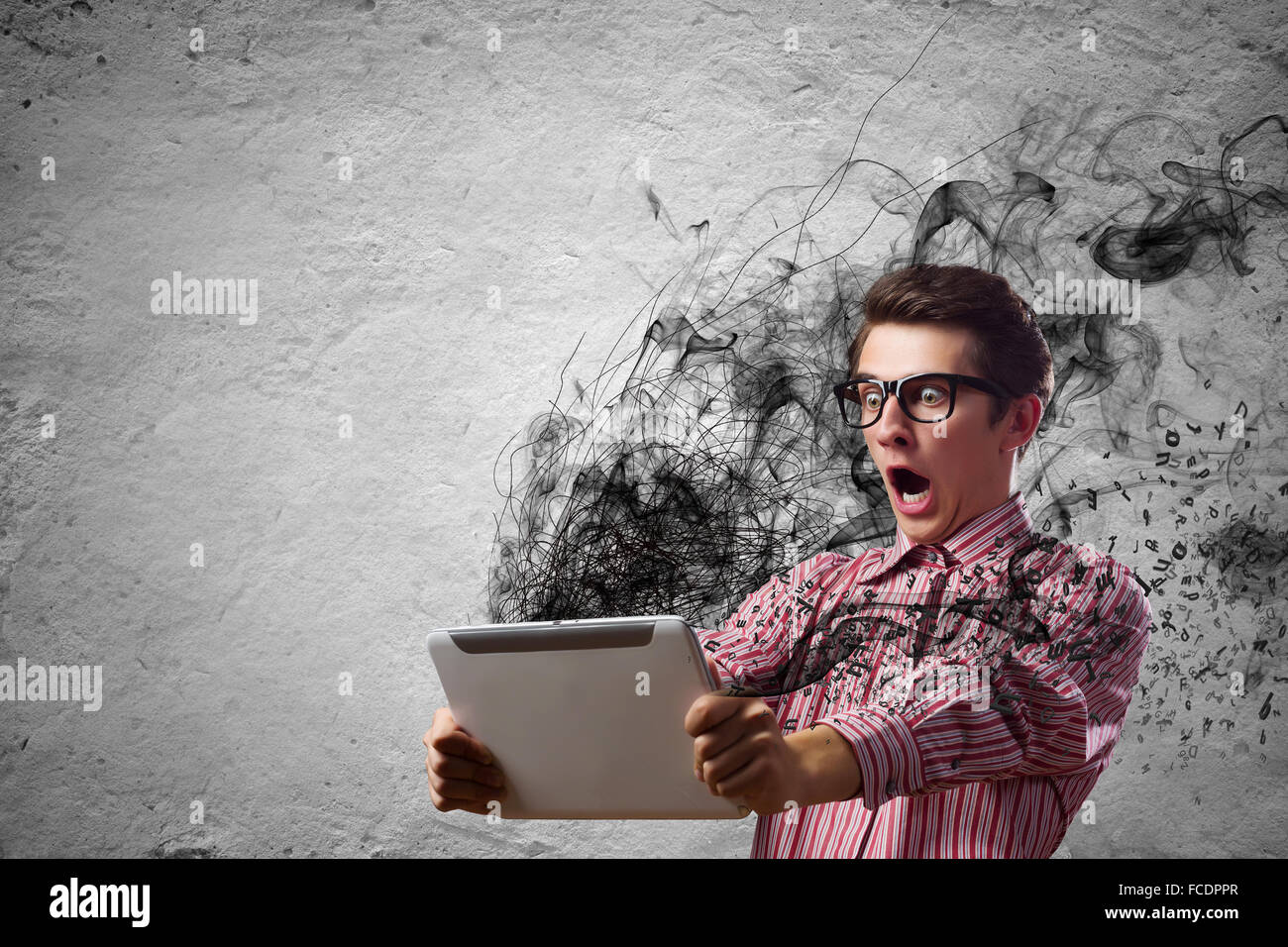 Young man looking shocked in tablet pc Stock Photo - Alamy