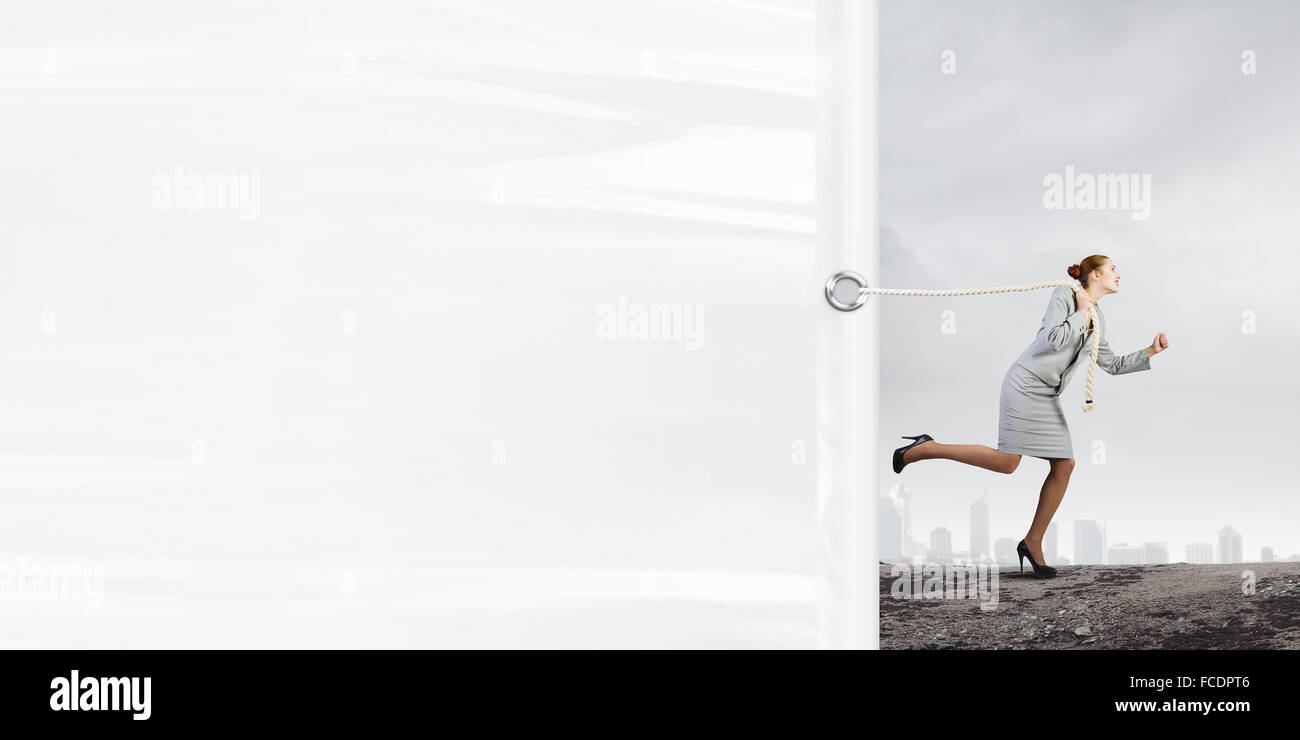 Young businesswoman running and pulling white blank banner Stock Photo ...
