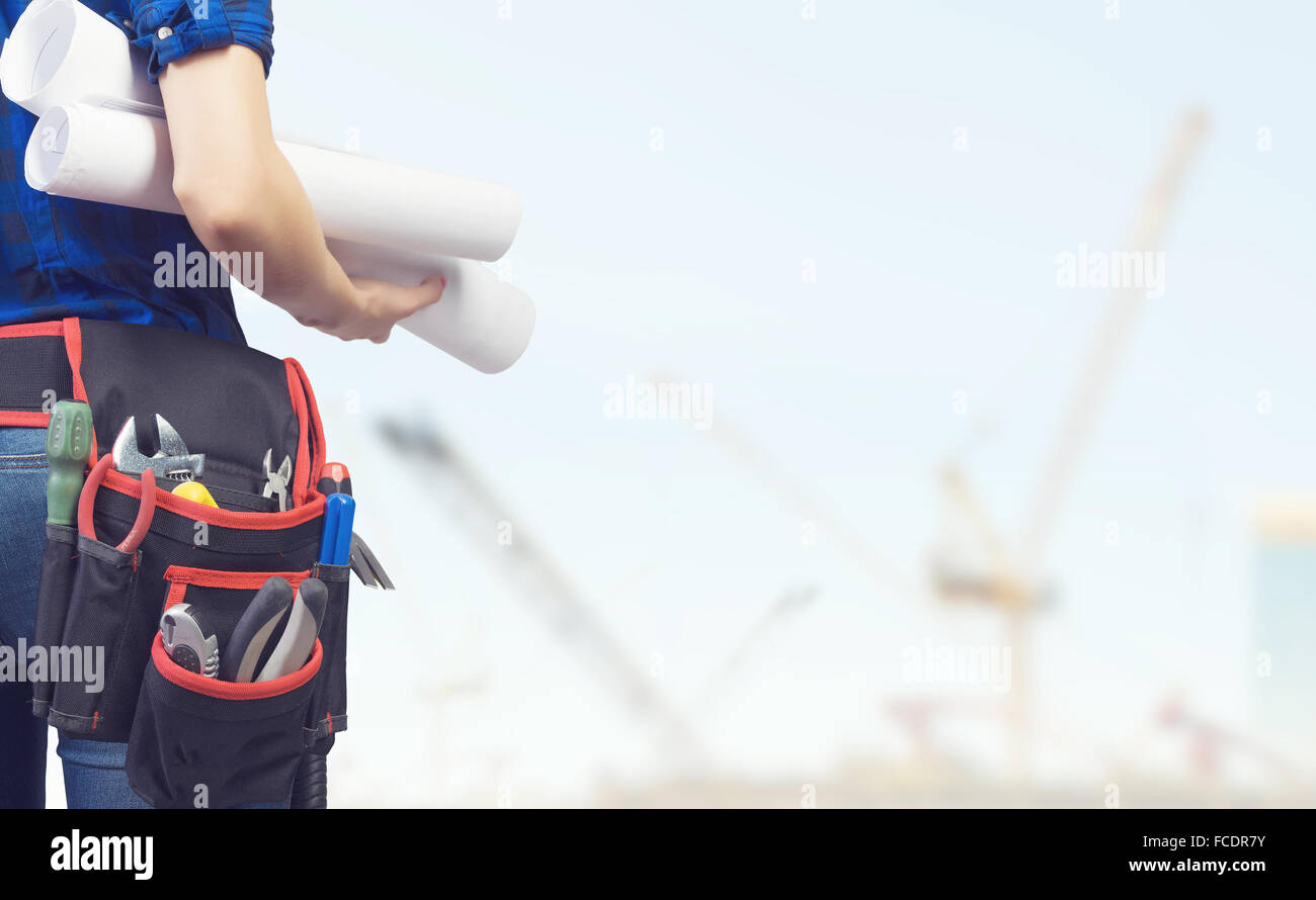 Close up of woman mechanic with project in hand against city background ...