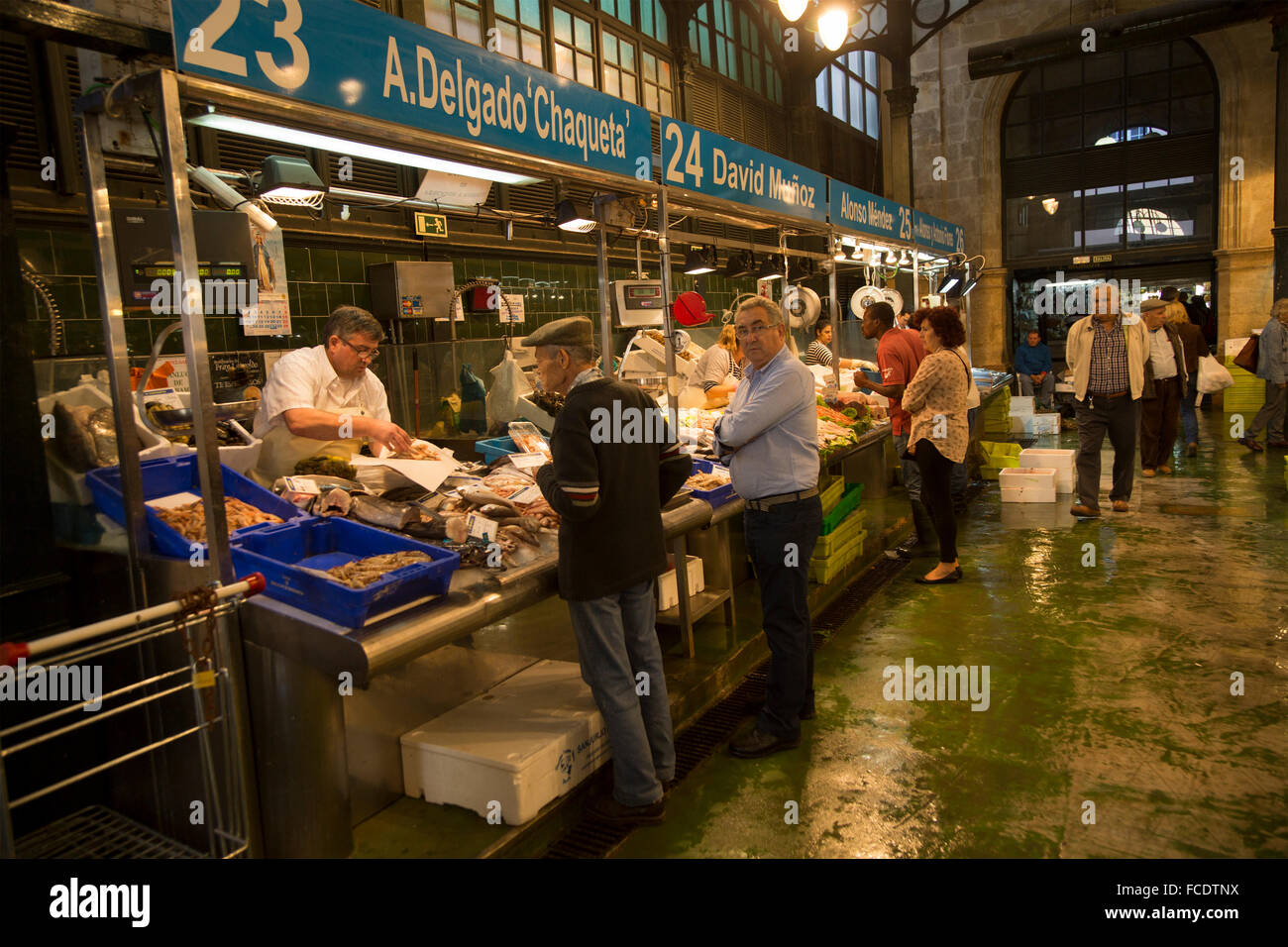People shopping at fishmonger stalls inside historic covered market ...