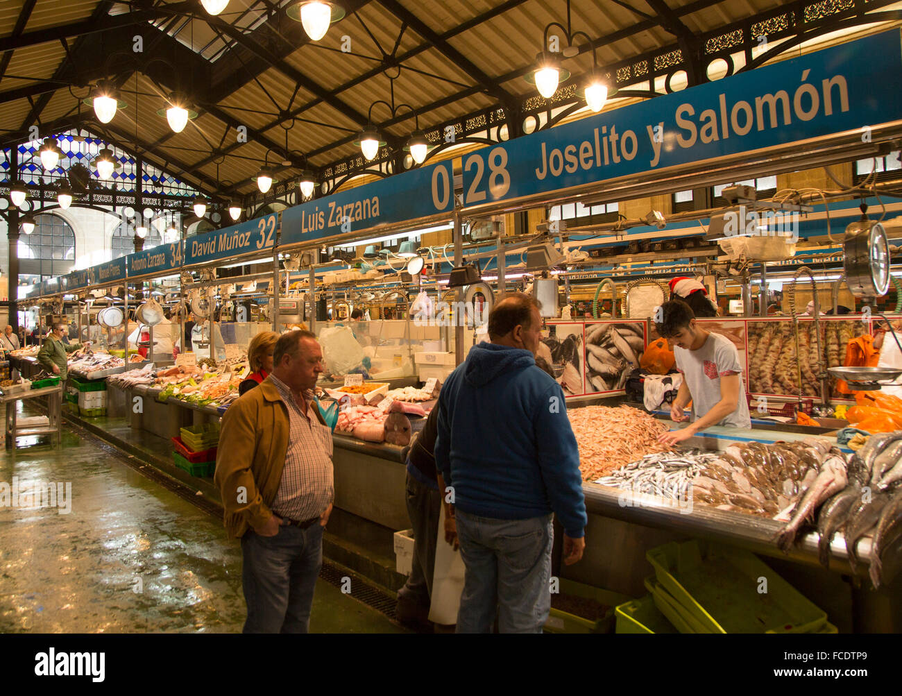 People shopping at fishmonger stalls inside historic covered market ...