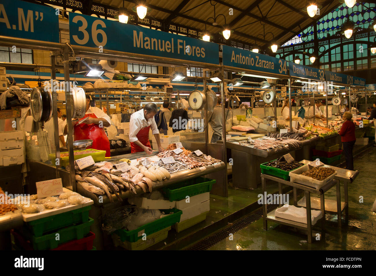 People shopping at fishmonger stalls inside historic covered market ...