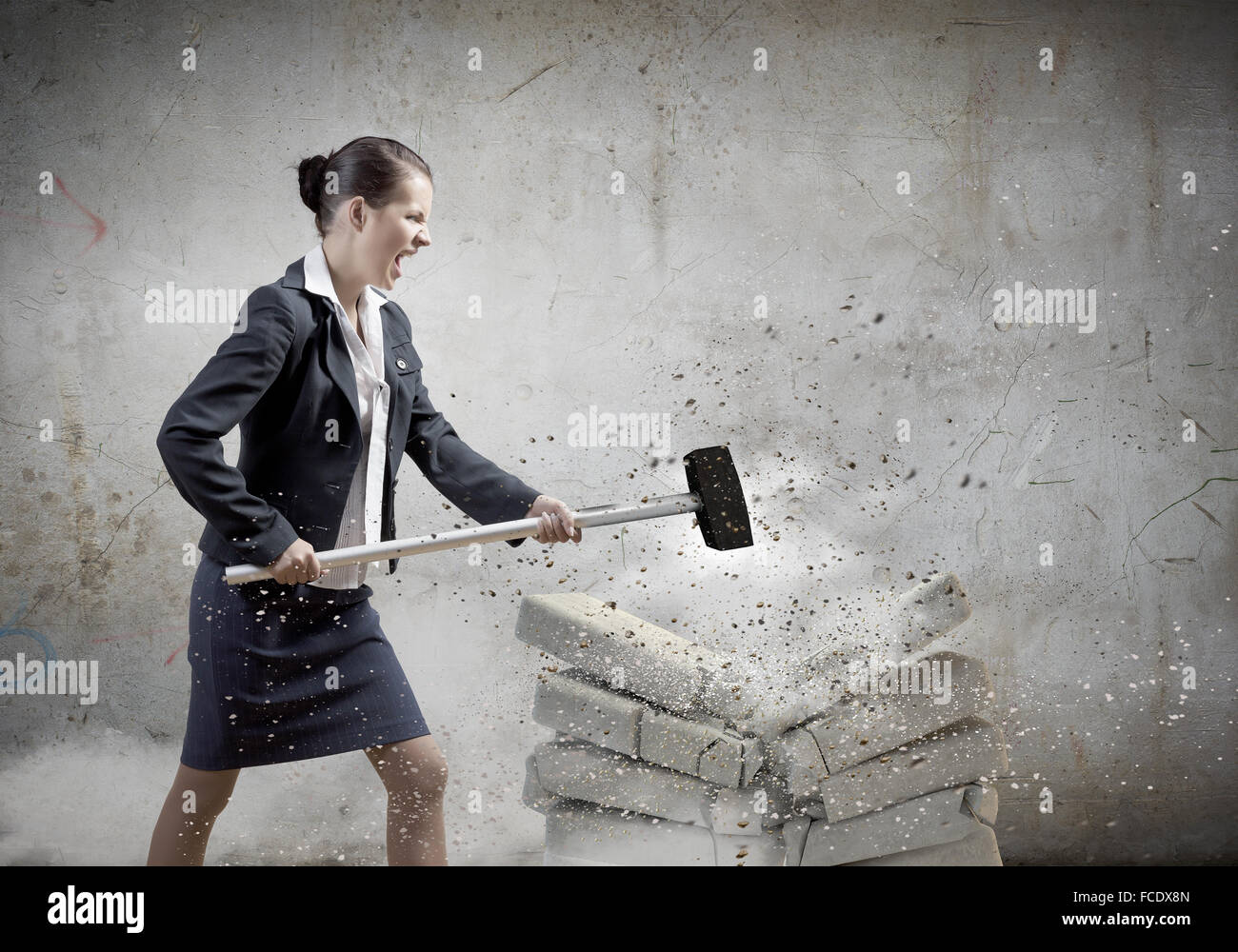 Young angry businesswoman crashing bricks with hammer Stock Photo - Alamy