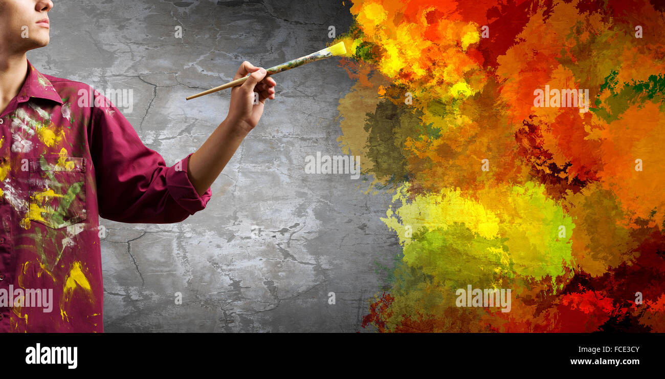 Young handsome man painter with brush in hand Stock Photo - Alamy