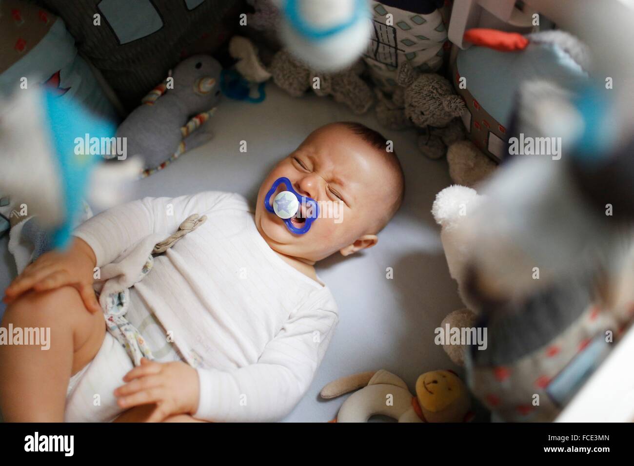 8 months baby boy crying in his bed Stock Photo - Alamy