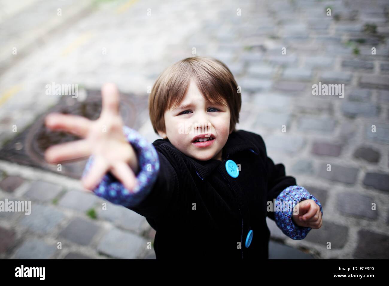 Little boy with outstretched hand in the street Stock Photo - Alamy