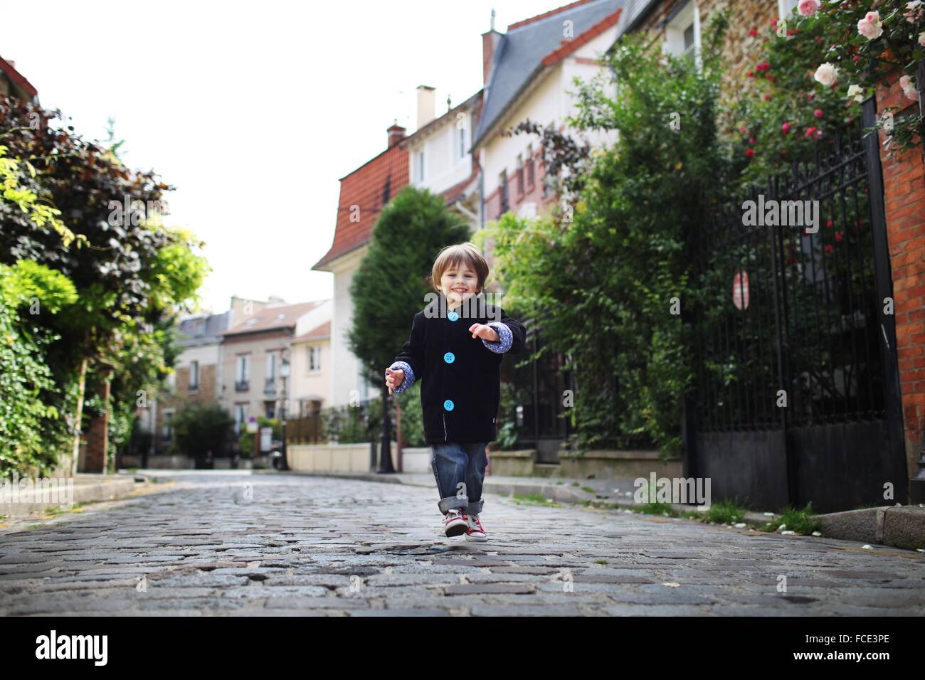 Little boy running in a cobbled narrow street Stock Photo - Alamy