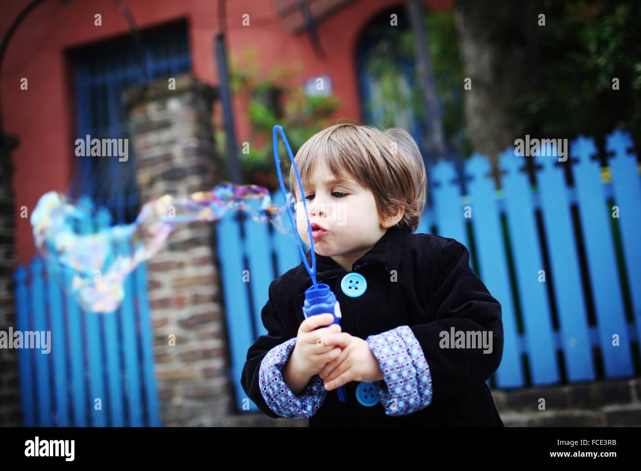 Little boy blowing bubbles in the street Stock Photo - Alamy