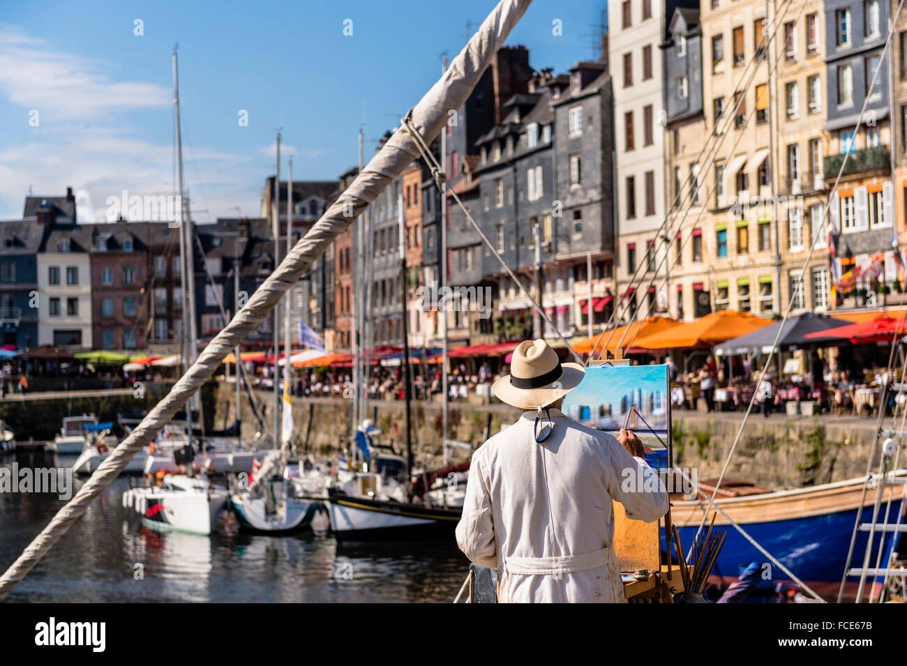 France, Normandy, artist painting in front of the old harbour in the ...