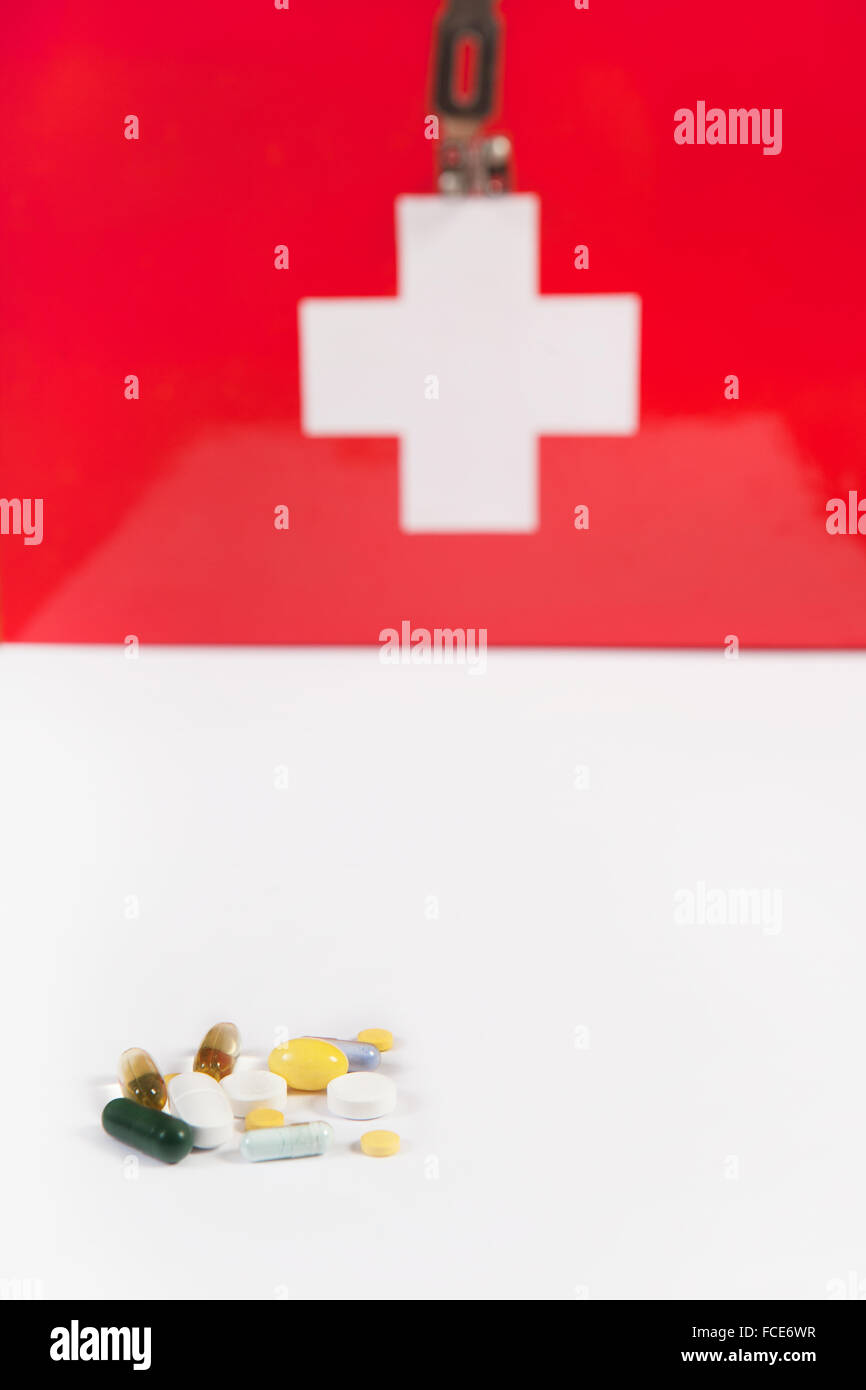 Pills and capsules in front of a red cross as a background Stock Photo ...