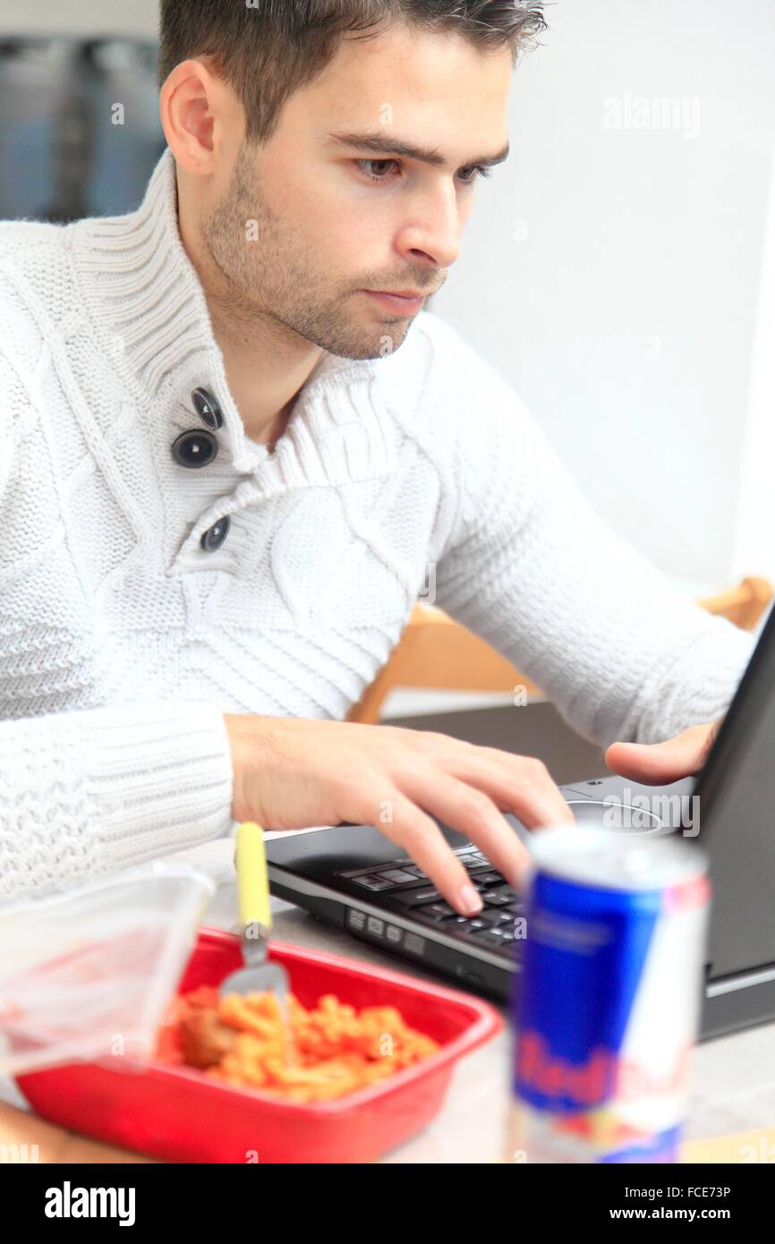 France, man eating and working with laptop Stock Photo - Alamy