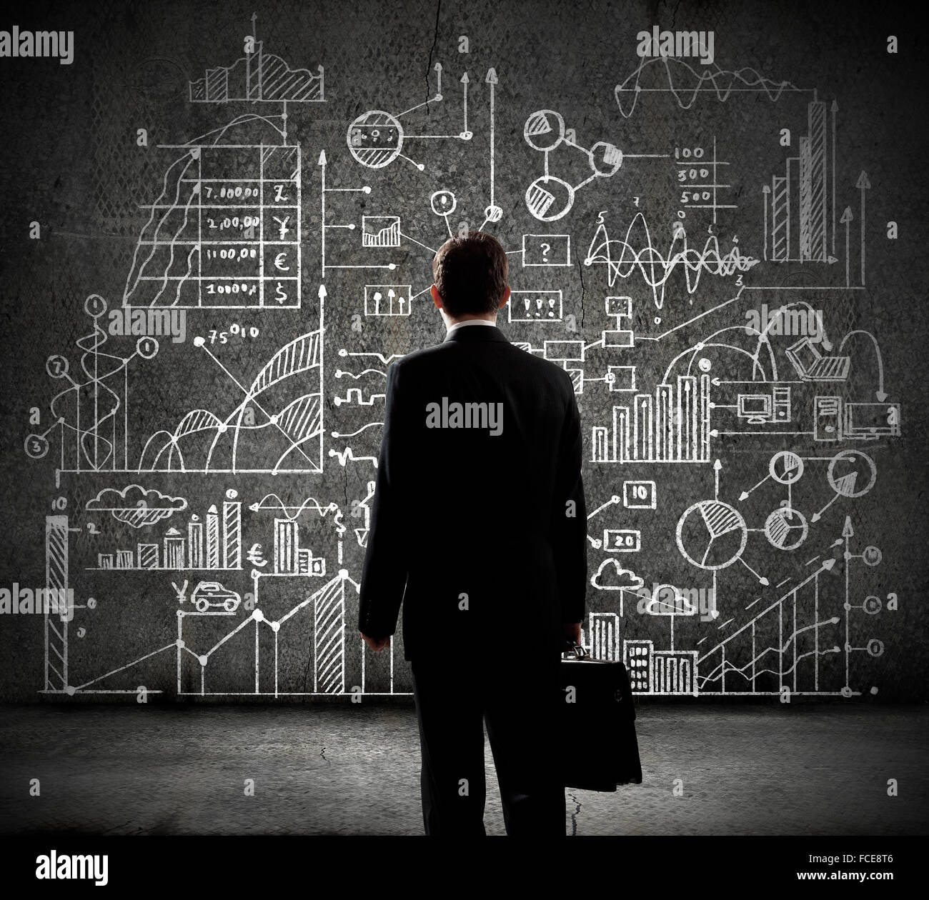 Rear view of businessman looking at wall with business sketches Stock ...