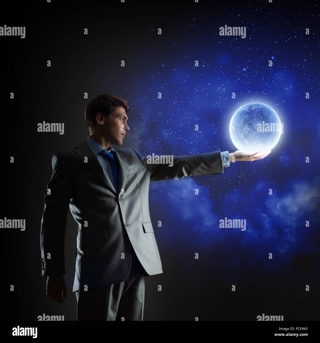 Young man in suit holding moon in palm Stock Photo - Alamy