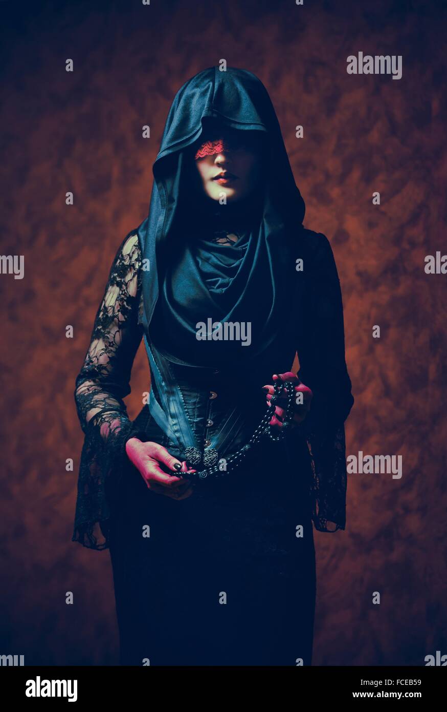 Portrait of a gothic woman holding a rosary Stock Photo - Alamy