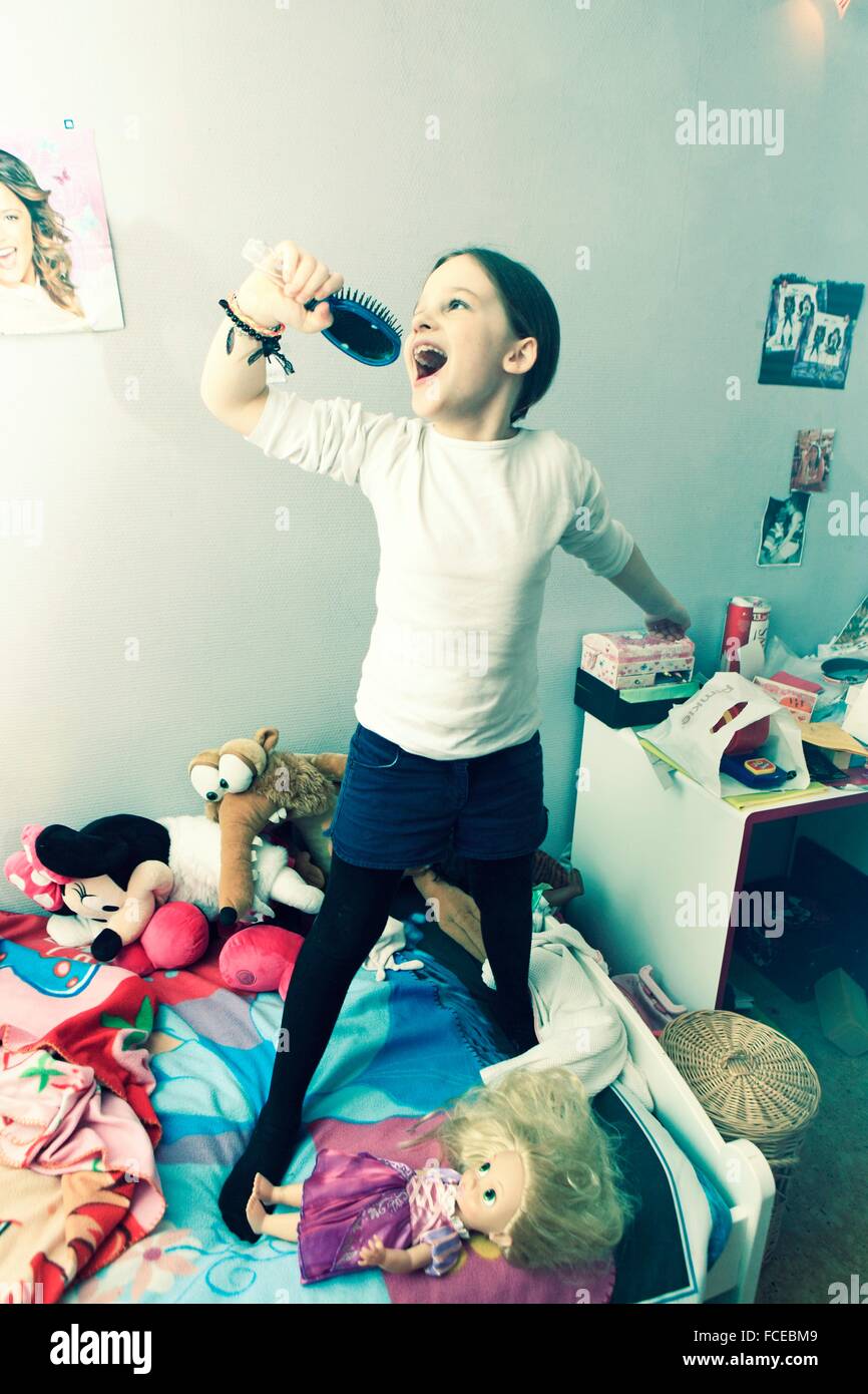 France, little girl singing on her bed at home Stock Photo - Alamy