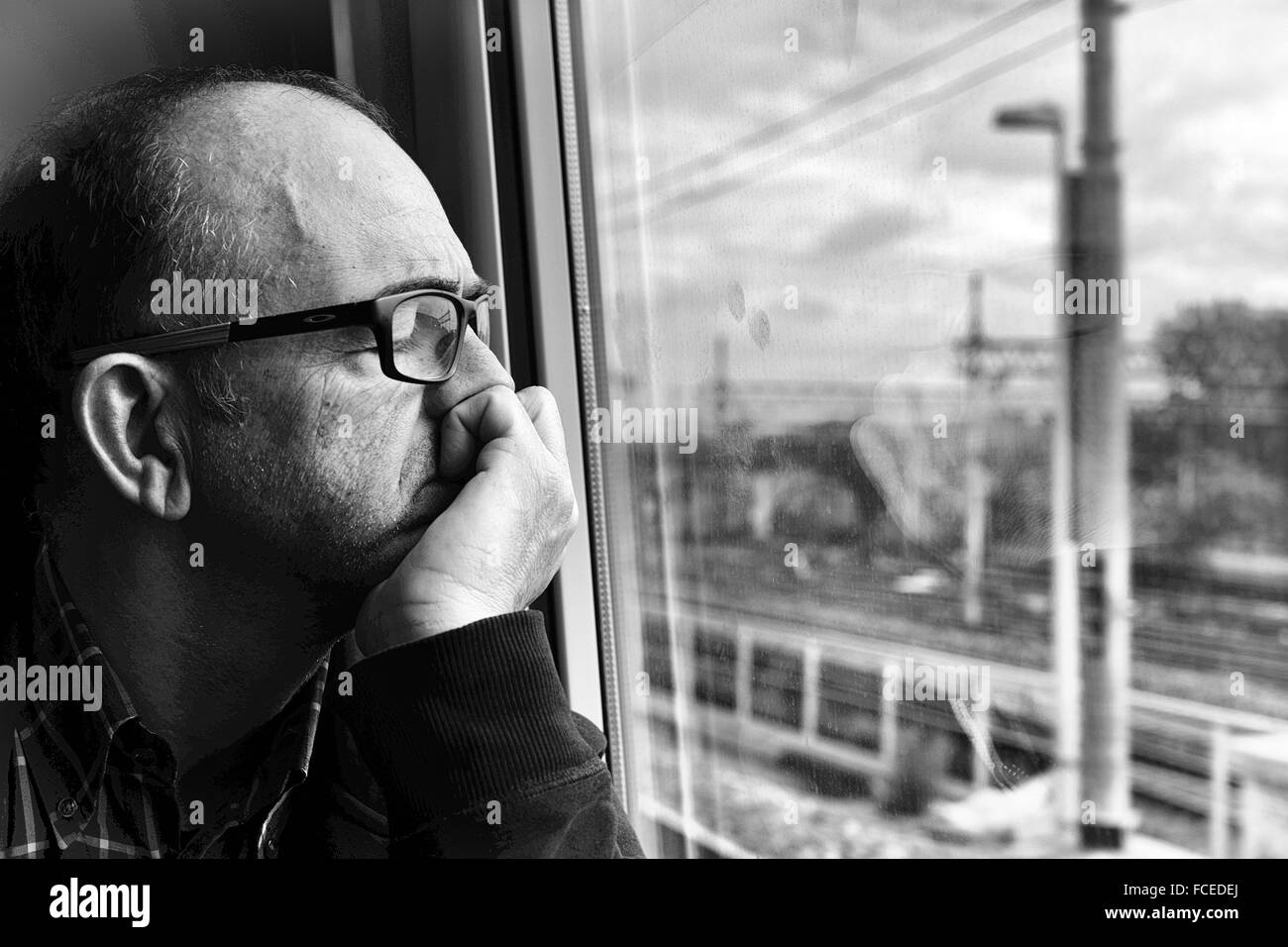 Man looking through train window Black and White Stock Photos & Images ...