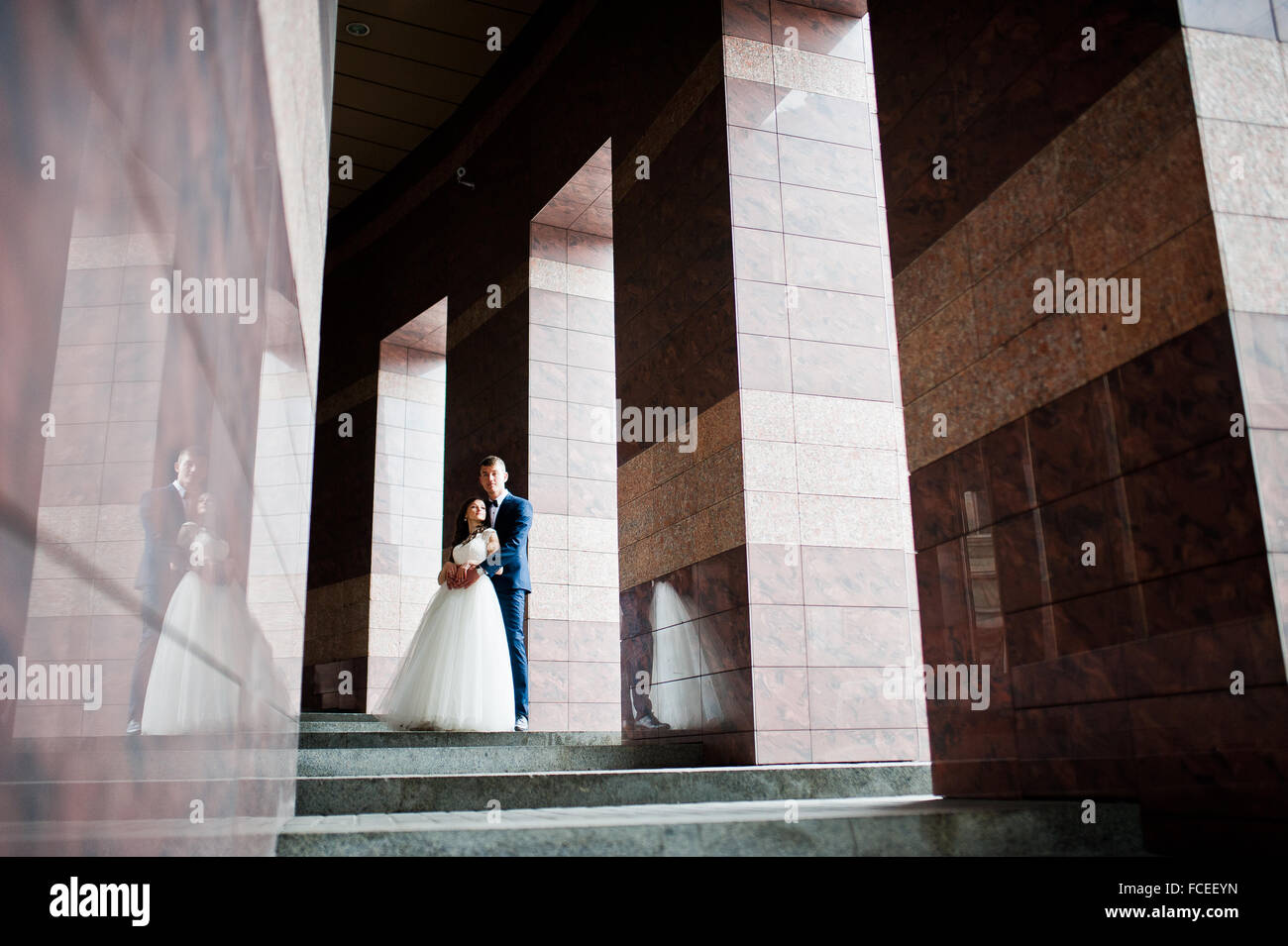 Wedding couple under high-tech columns with shadows Stock Photo - Alamy