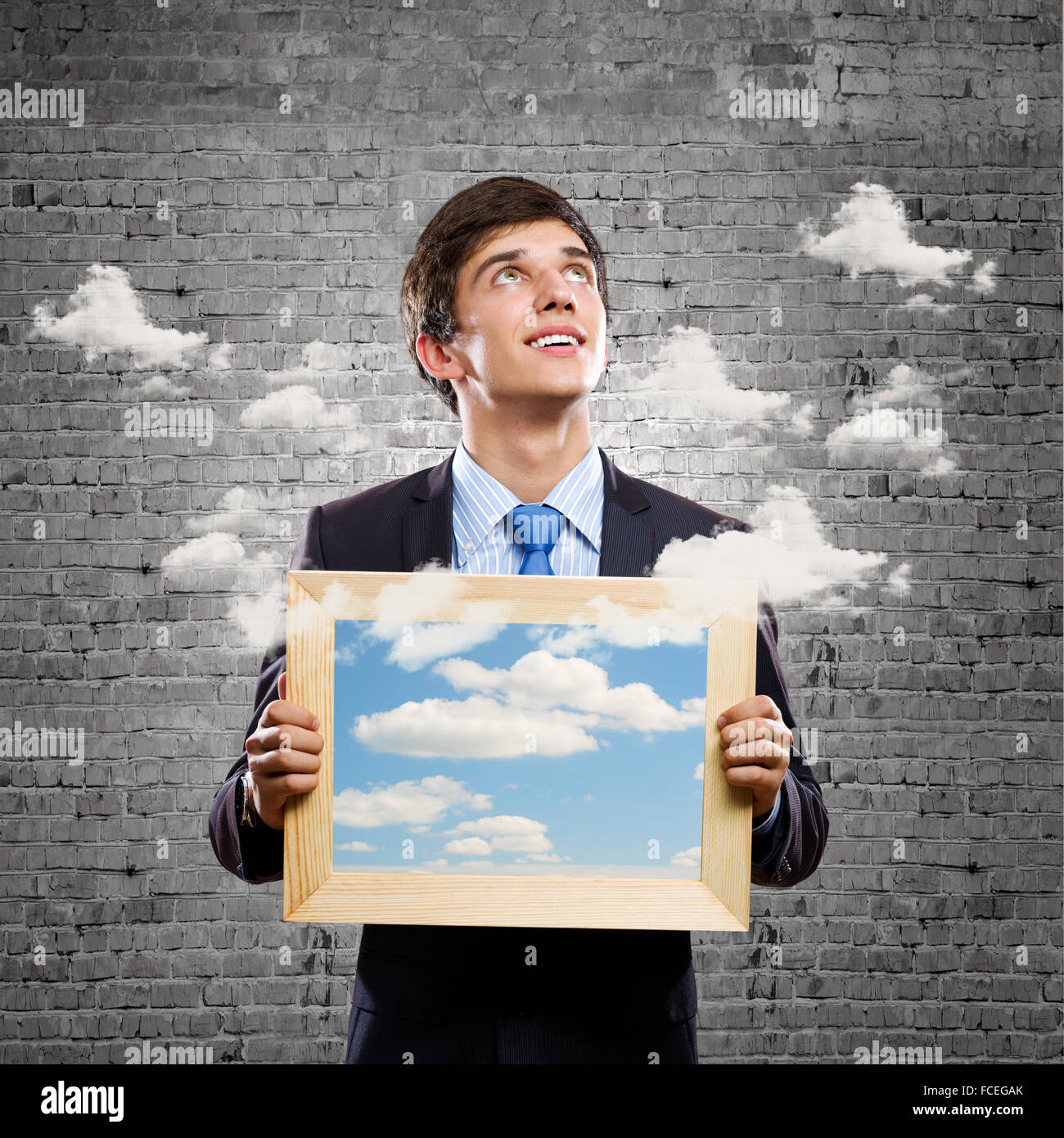 Handsome young man holding frame with pictures Stock Photo - Alamy
