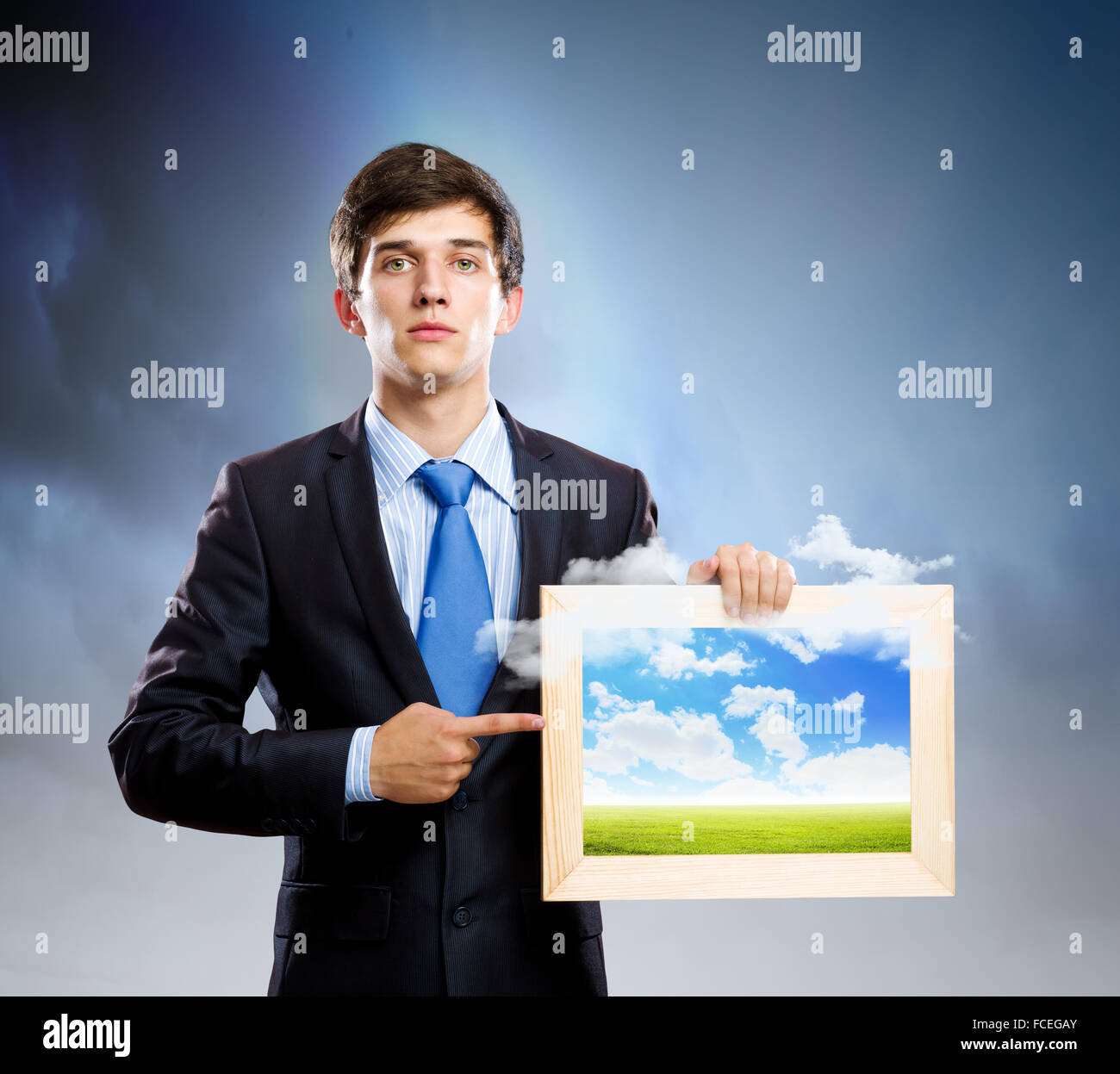 Handsome young man holding frame with pictures Stock Photo - Alamy