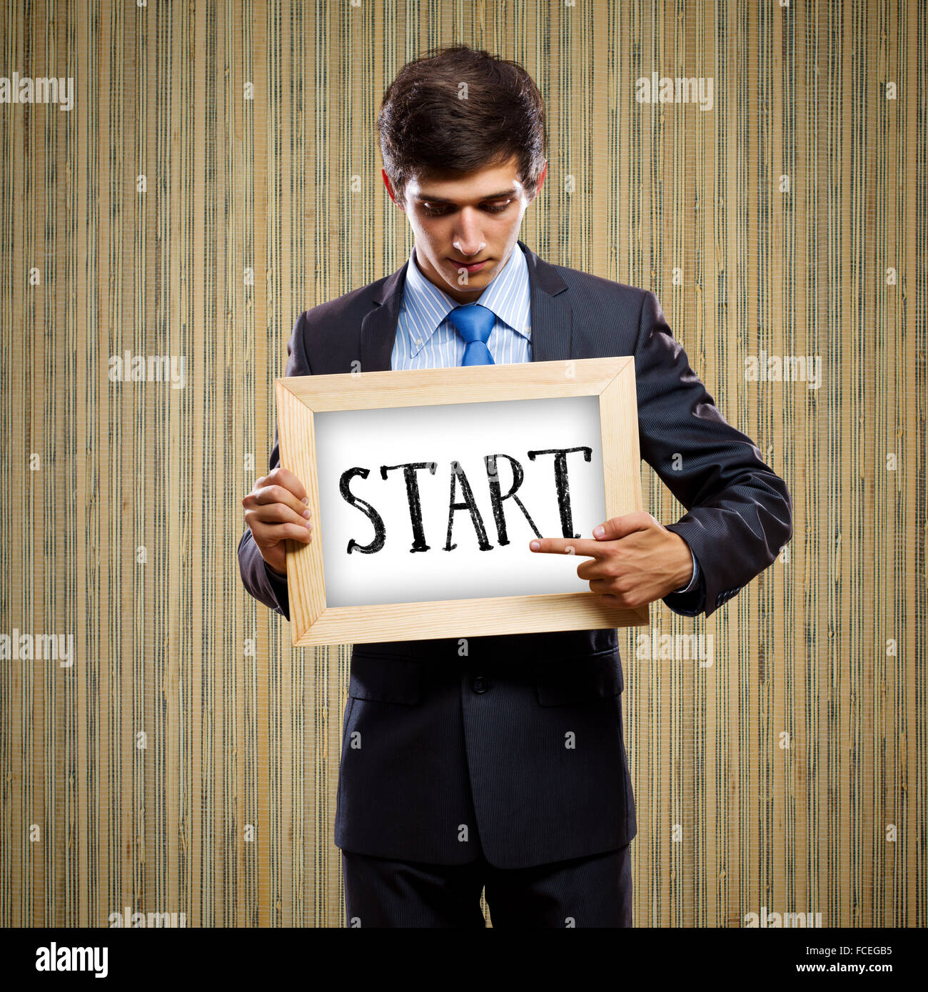 Handsome businessman holding frame with business sketches Stock Photo ...