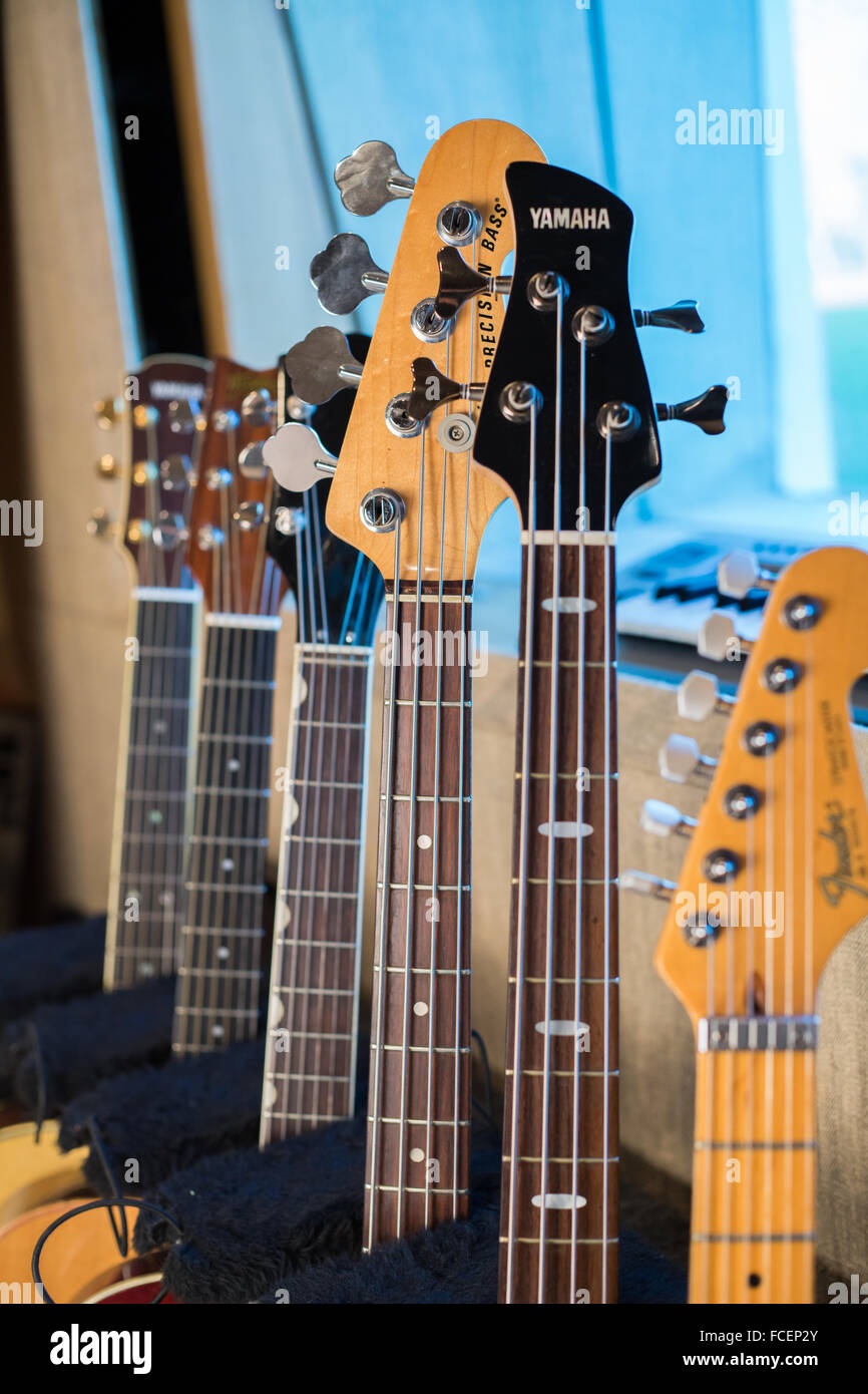 Electric guitars, acoustic guitars and electric bass guitars on a rack ...