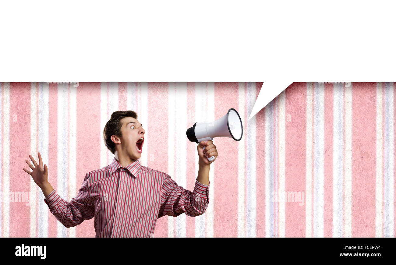 Young man in casual screaming in megaphone Stock Photo - Alamy
