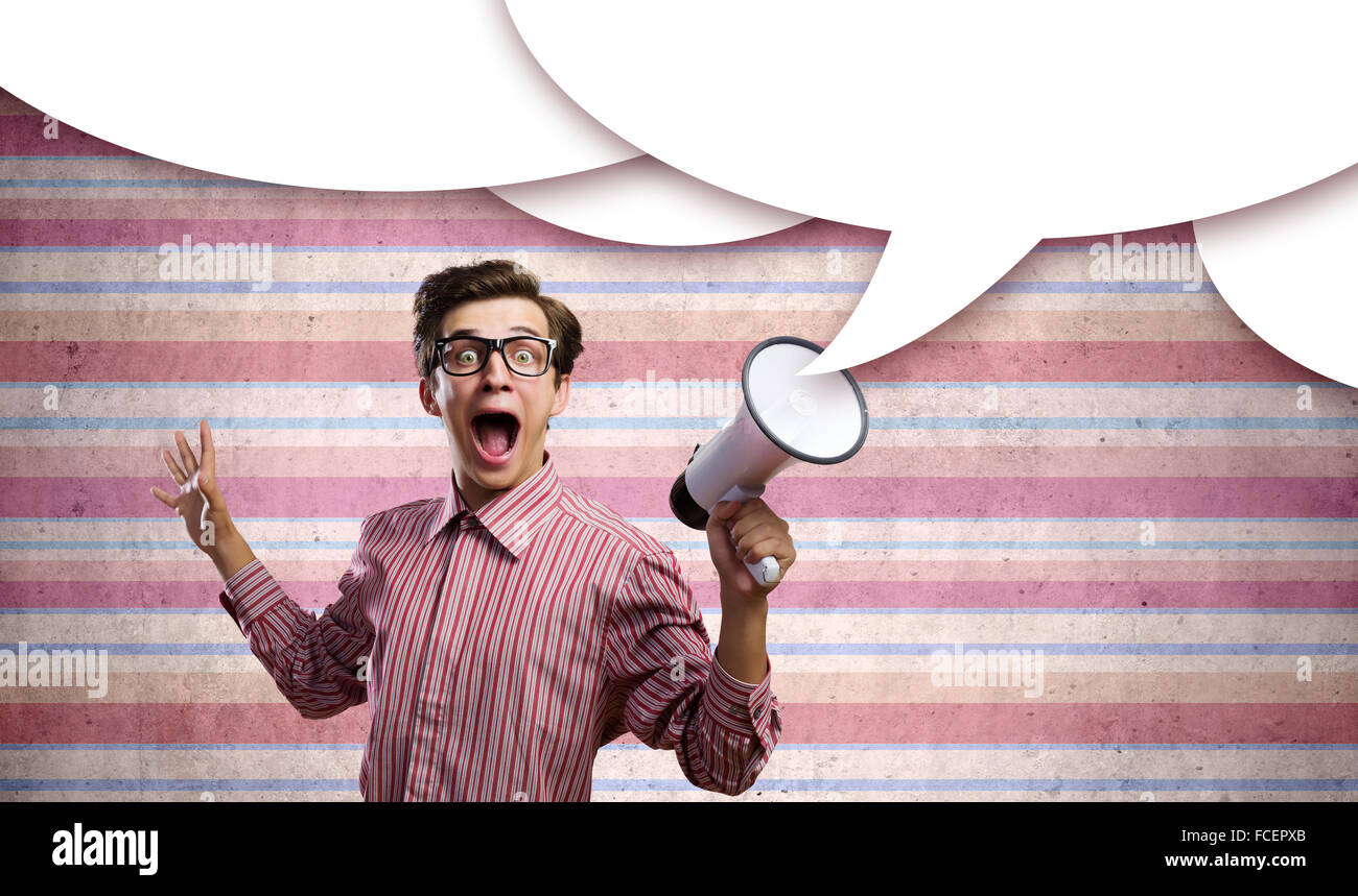 Young man in casual screaming in megaphone Stock Photo - Alamy