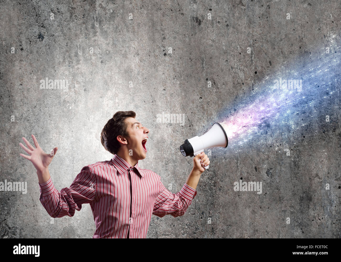 Young man in casual screaming in megaphone Stock Photo - Alamy