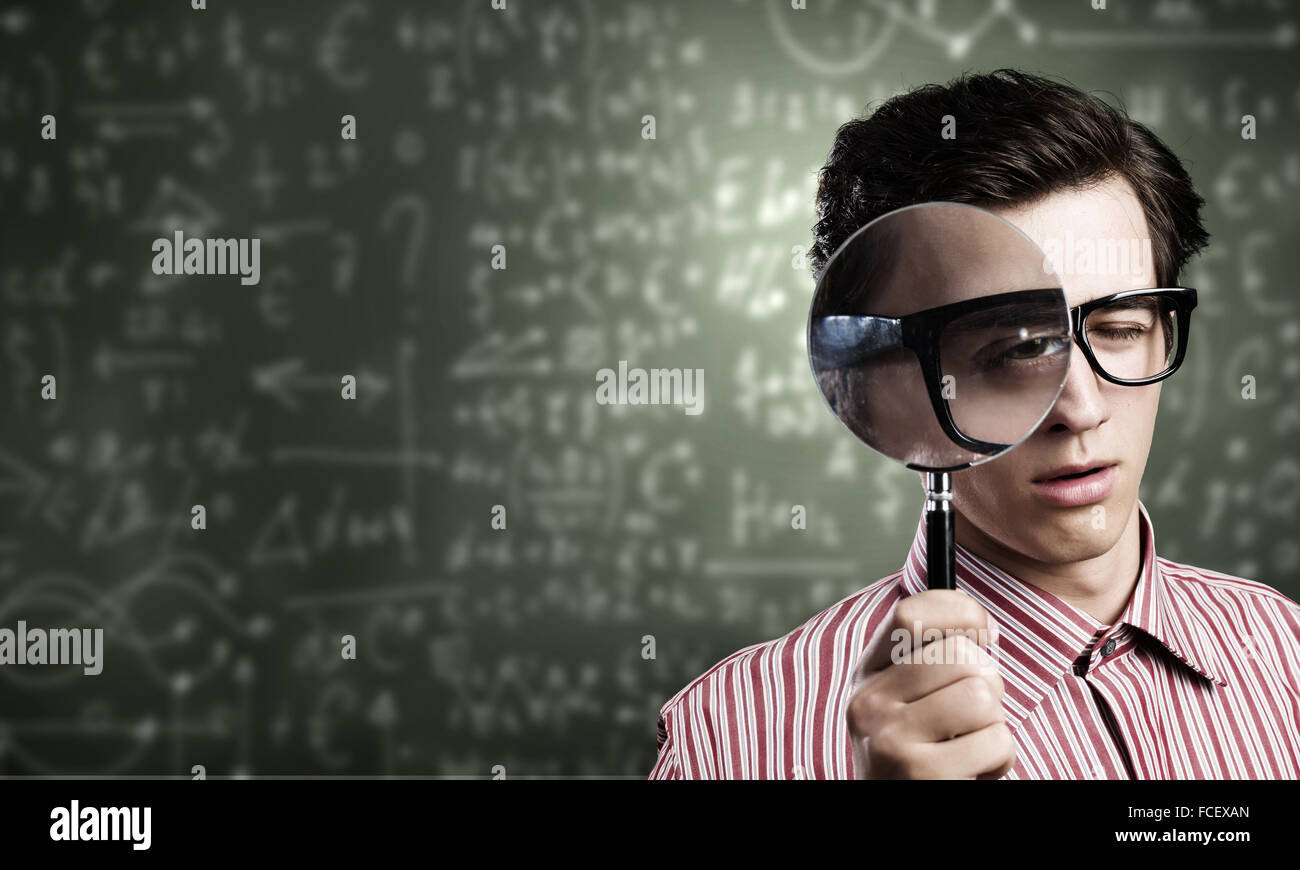 Young man scientist looking in magnifying glass Stock Photo - Alamy