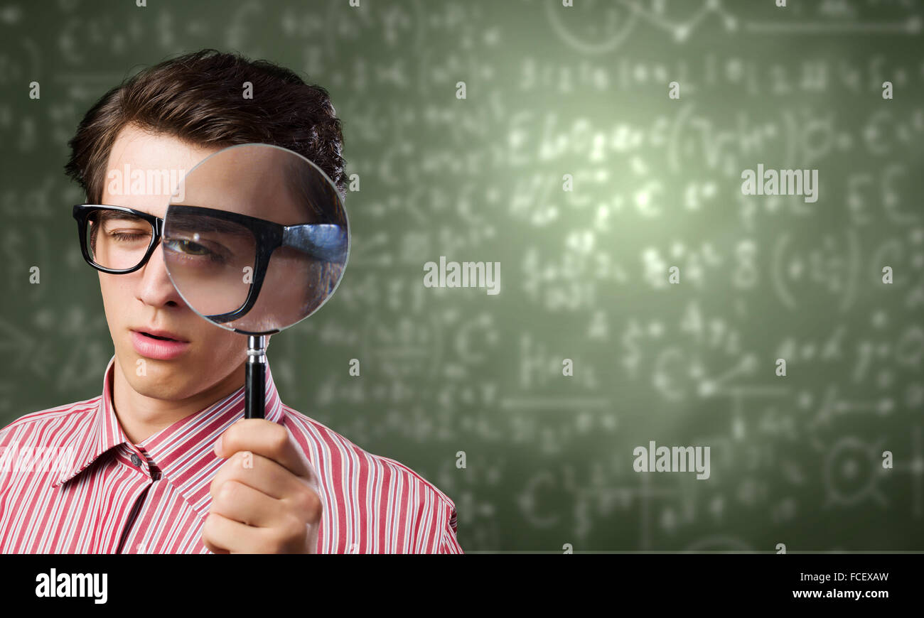 Young man scientist looking in magnifying glass Stock Photo - Alamy