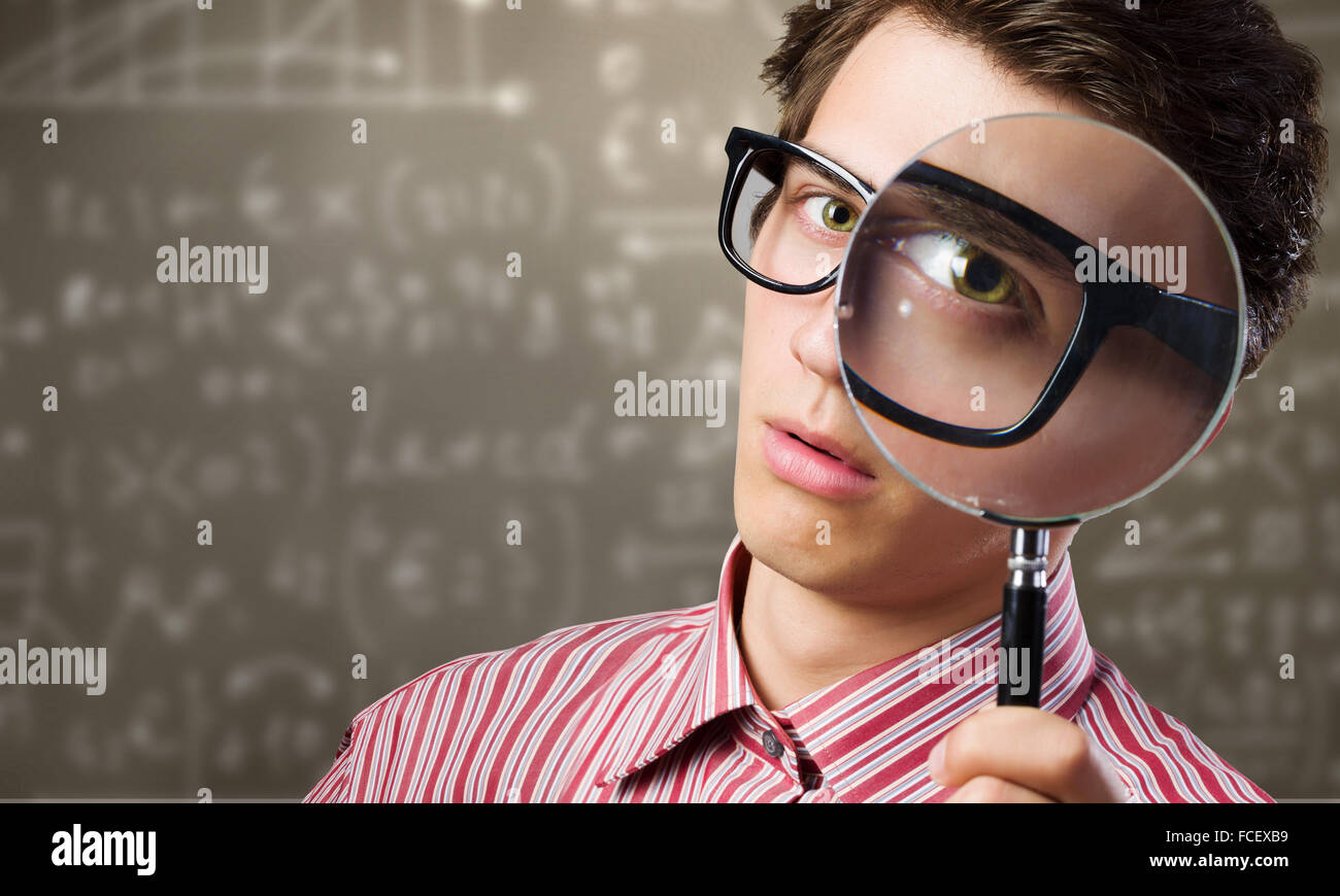 Young man scientist looking in magnifying glass Stock Photo - Alamy