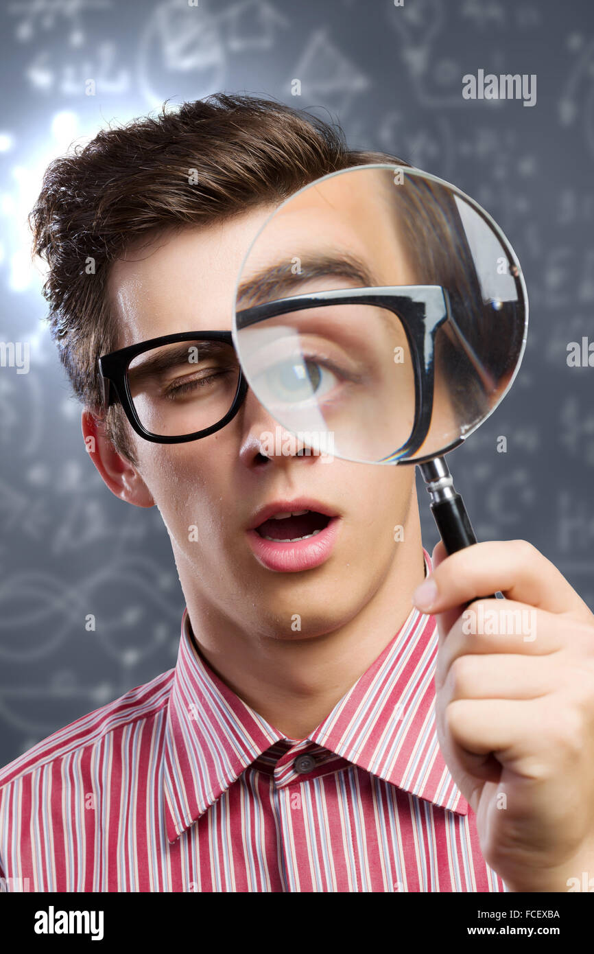 Young man scientist looking in magnifying glass Stock Photo - Alamy