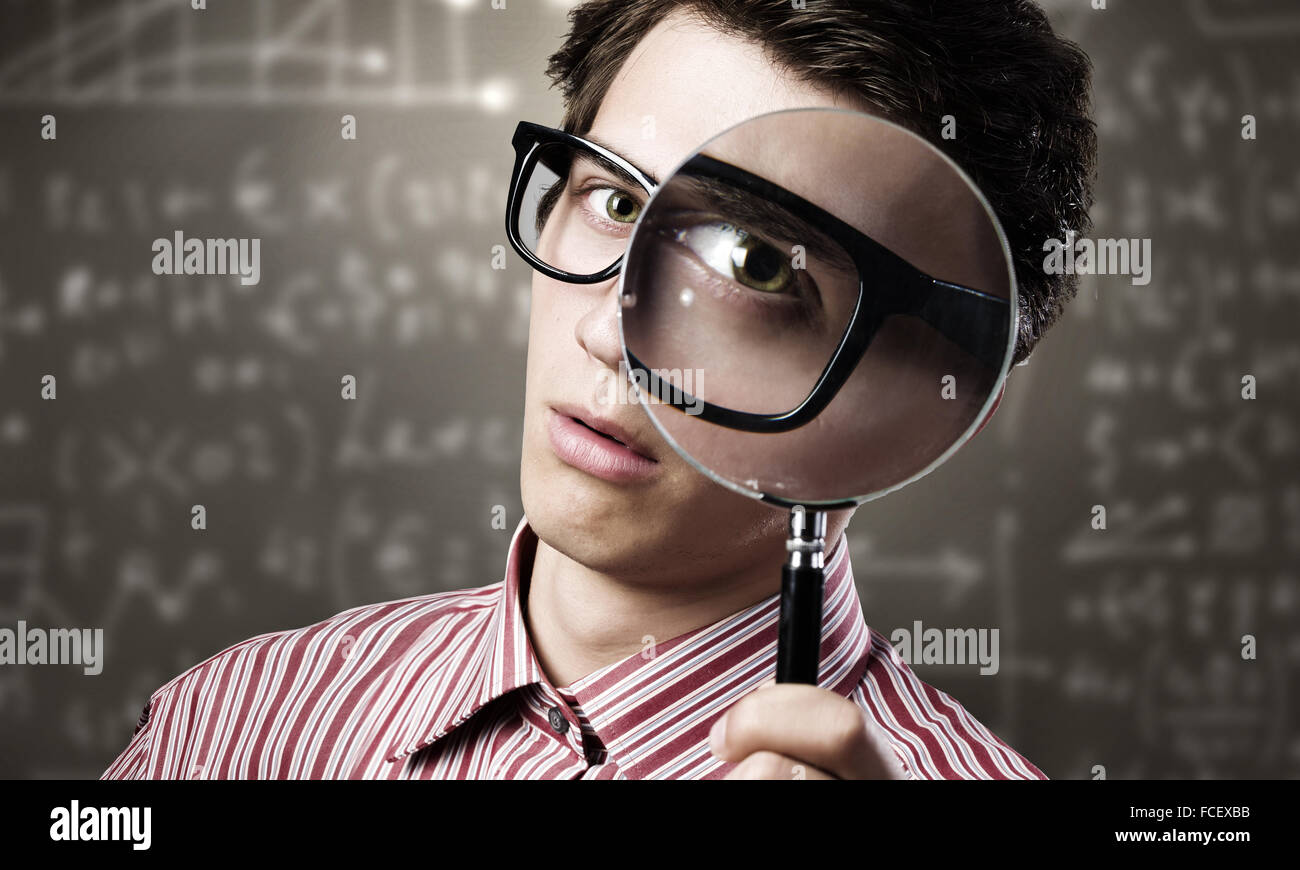 Young man scientist looking in magnifying glass Stock Photo - Alamy